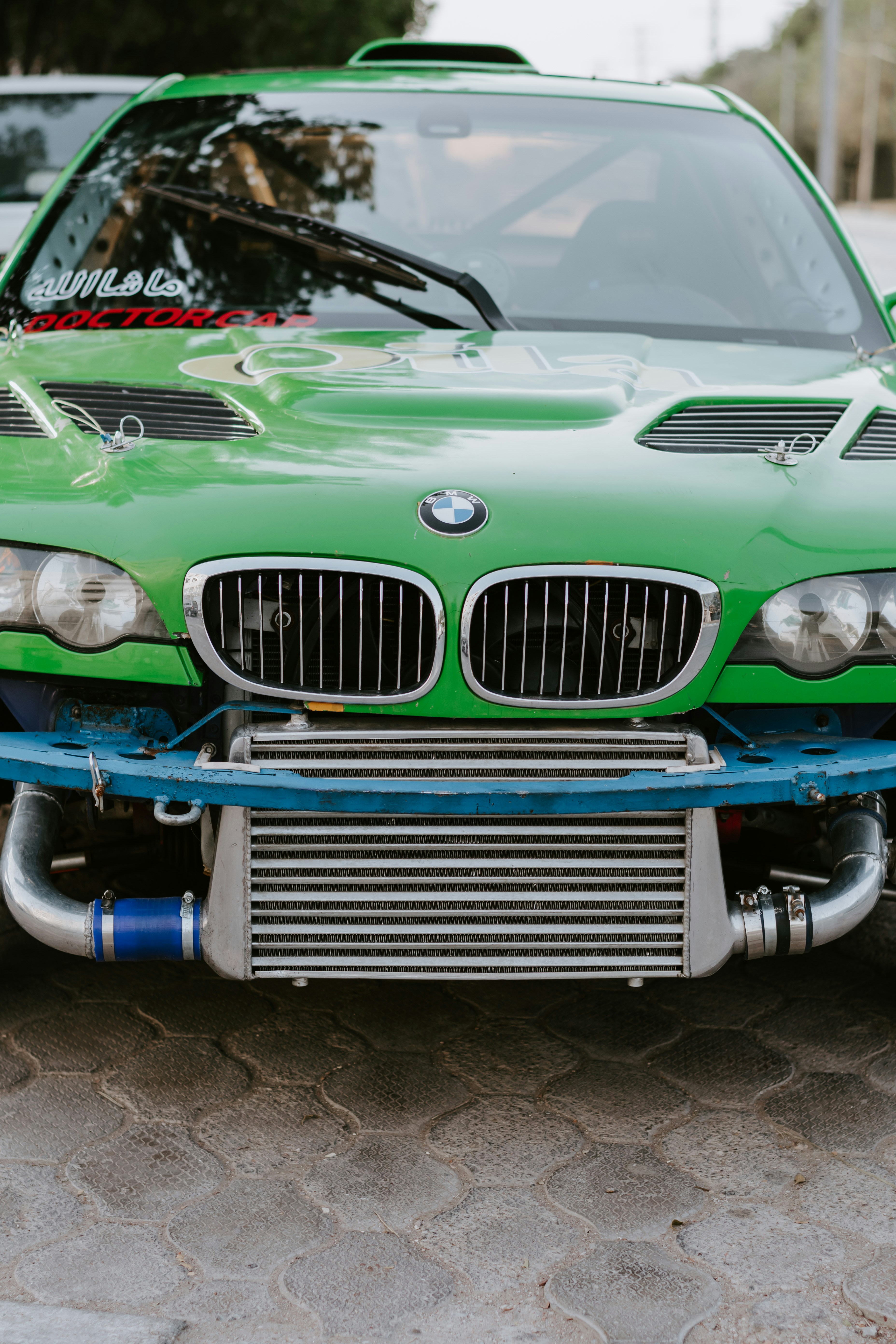 Front-and-center: a lime-green BMW race car with an exposed intercooler and vivid blue bumper