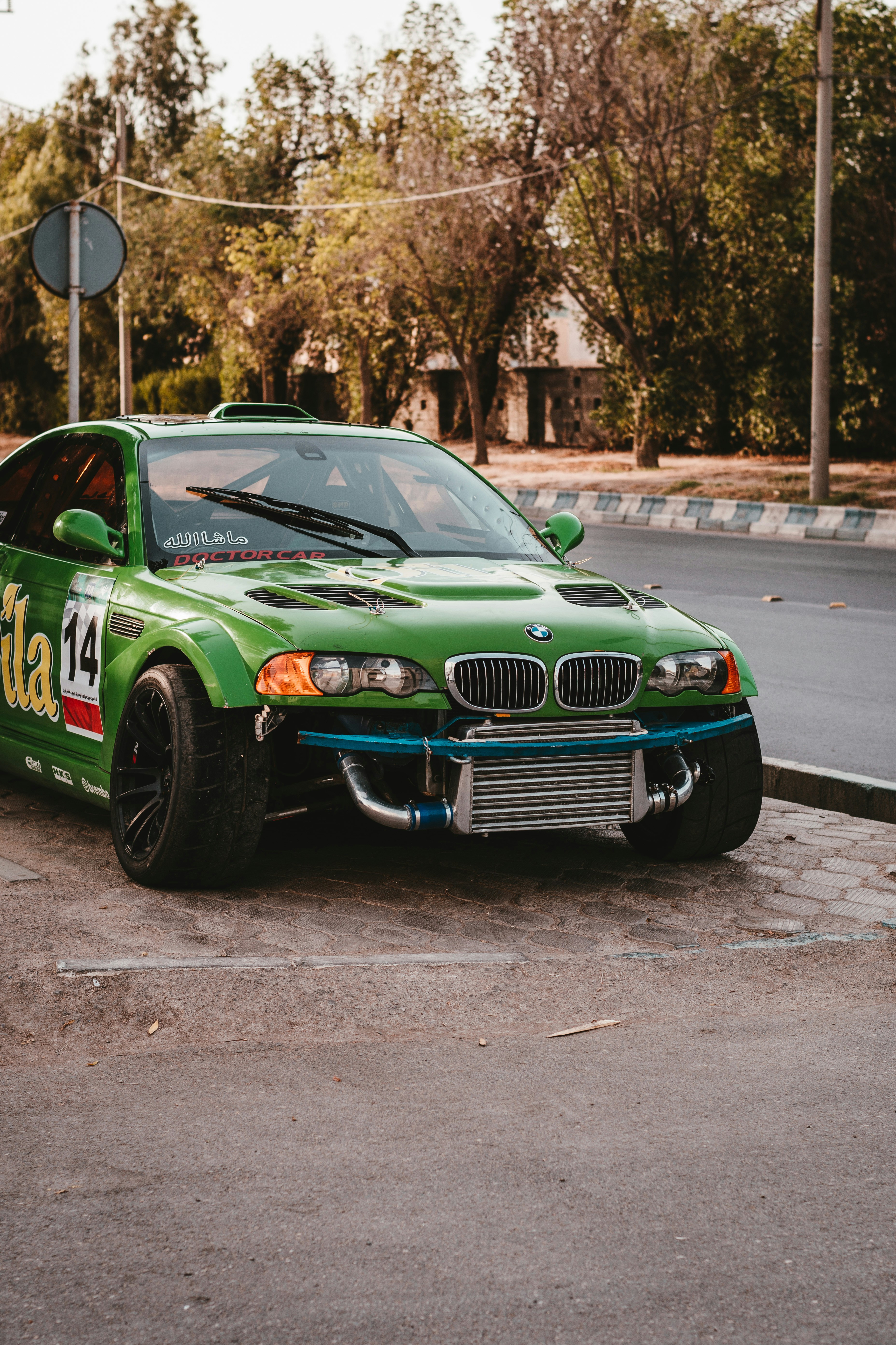 Green racing coupe on a curbside scouting for a win