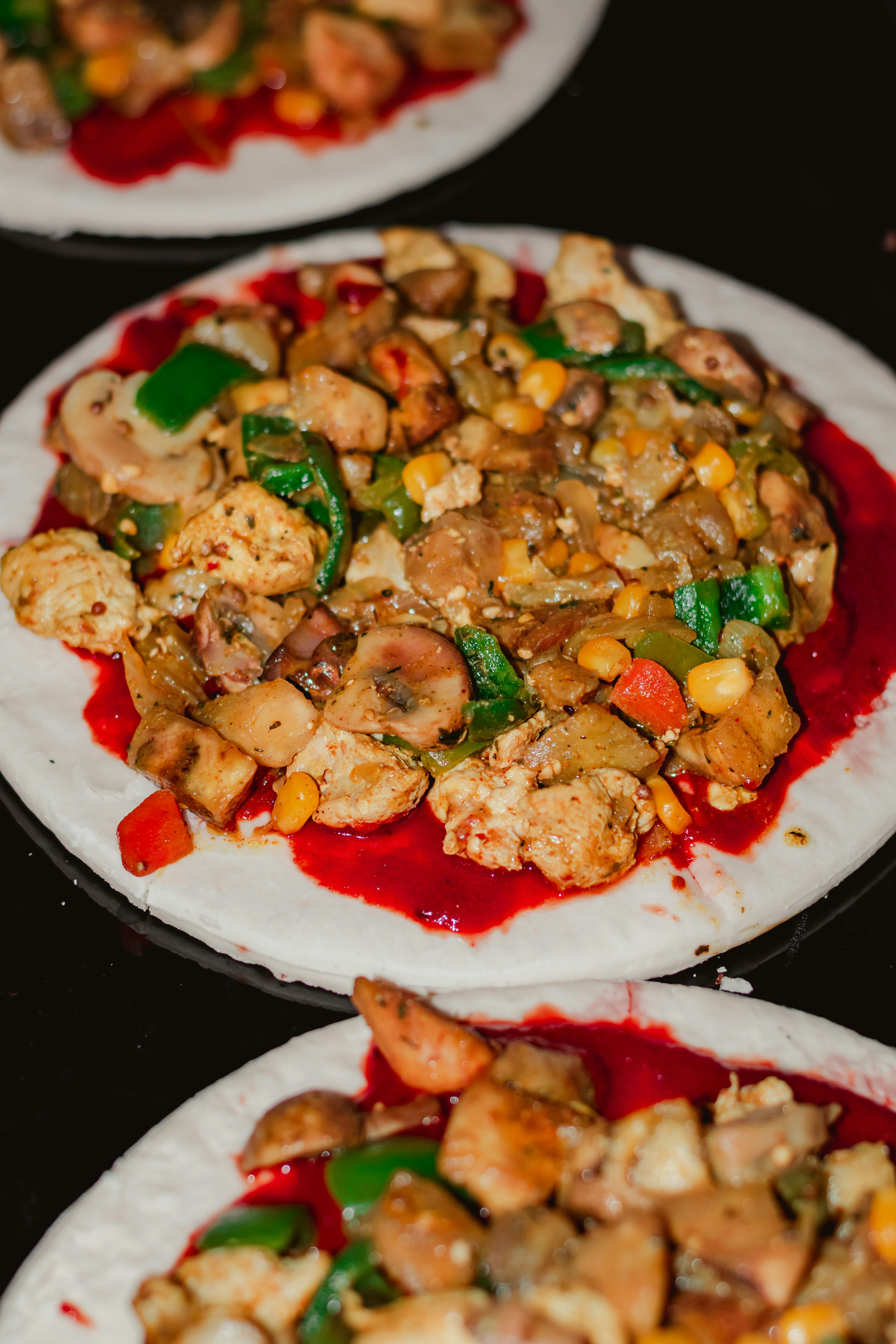Colorful Chicken and Veggie Pizza Discs with Red Sauce Drizzle