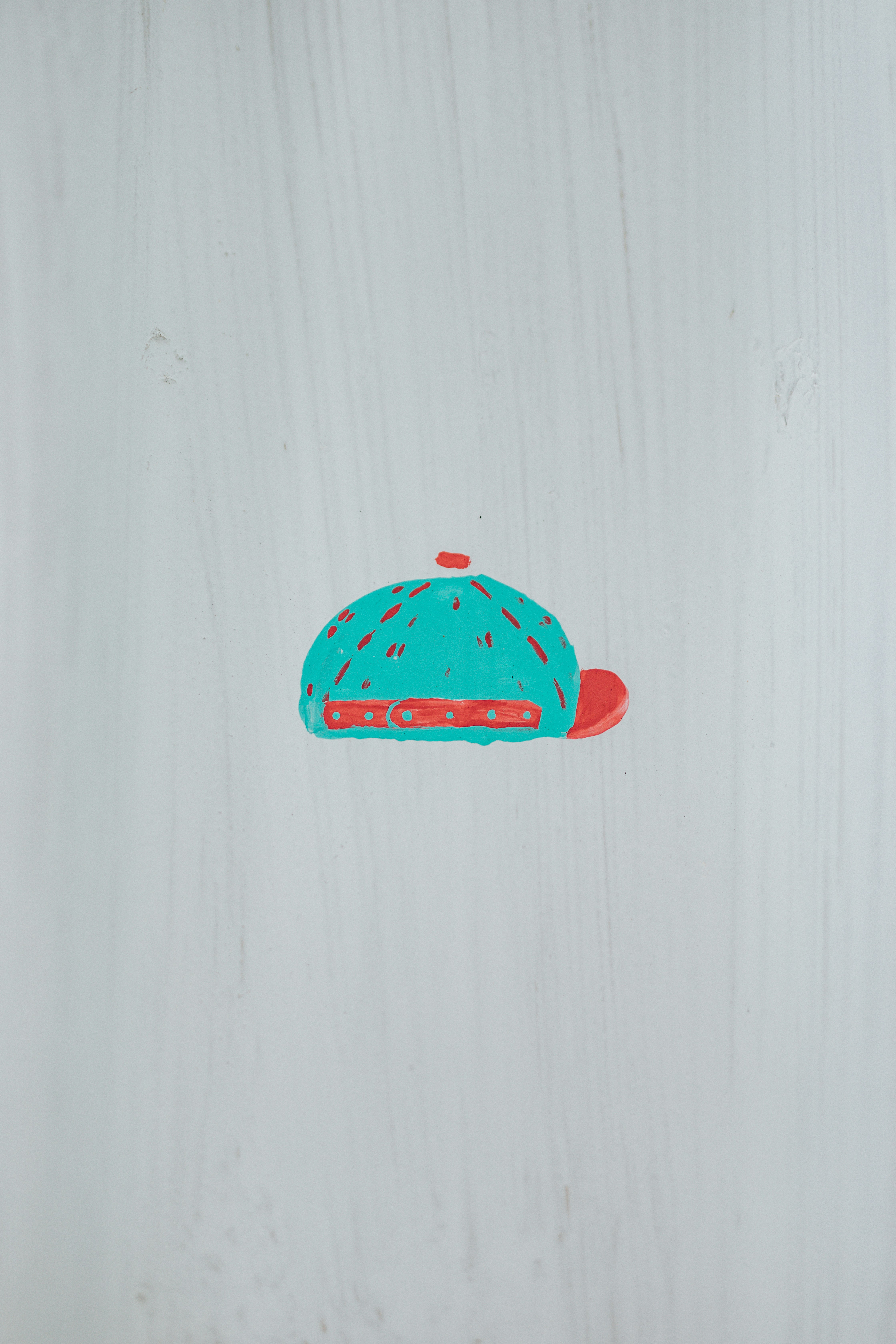 Brightly colored cap illustration against a textured white wooden background.