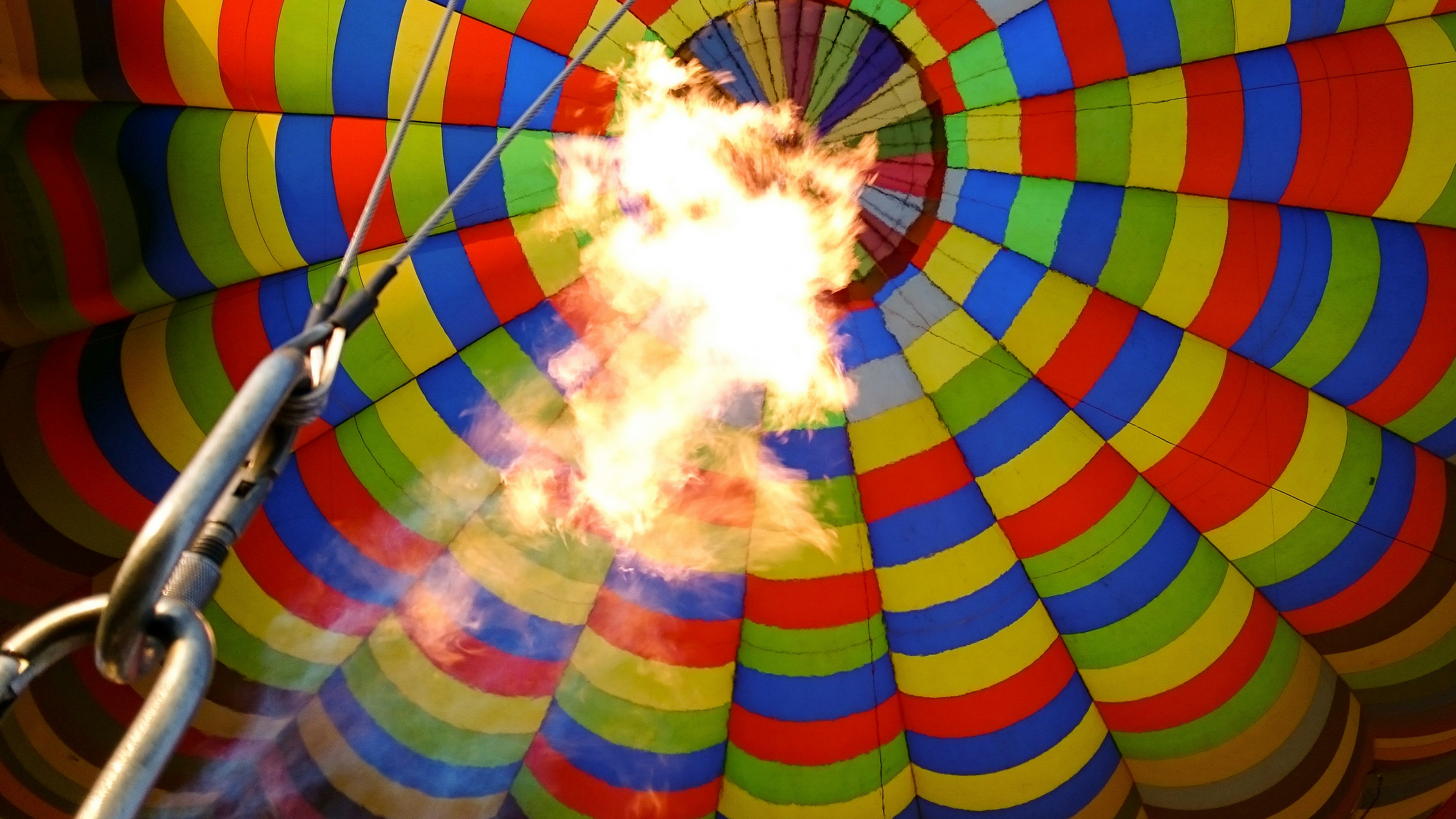 Fiery Burst at the Heart of a Rainbow Balloon Canopy
