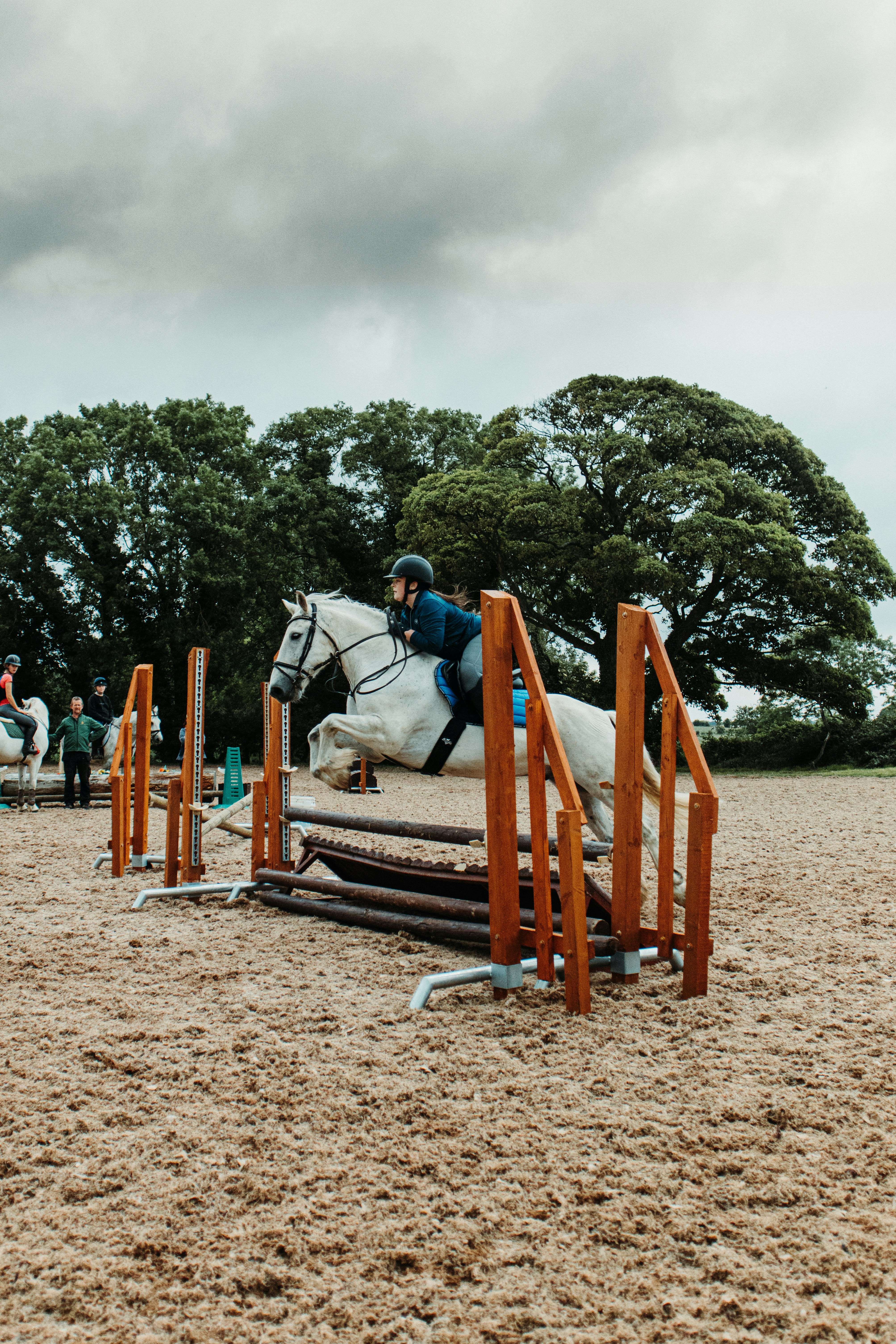 Leap of Focus: Rider and White Horse Clear the Jump