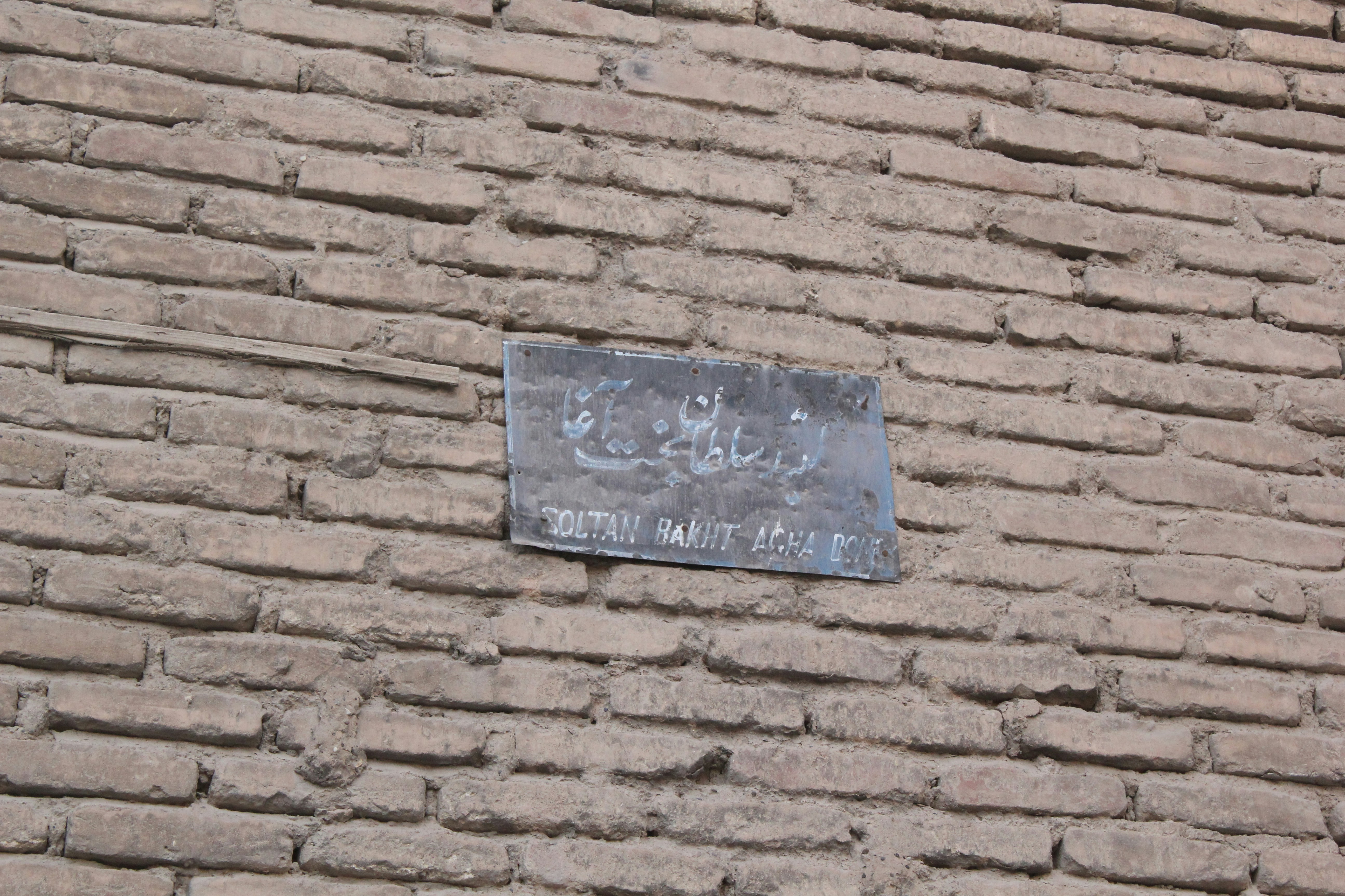 A Silent Marker: Weathered Plaque on Brick Facade