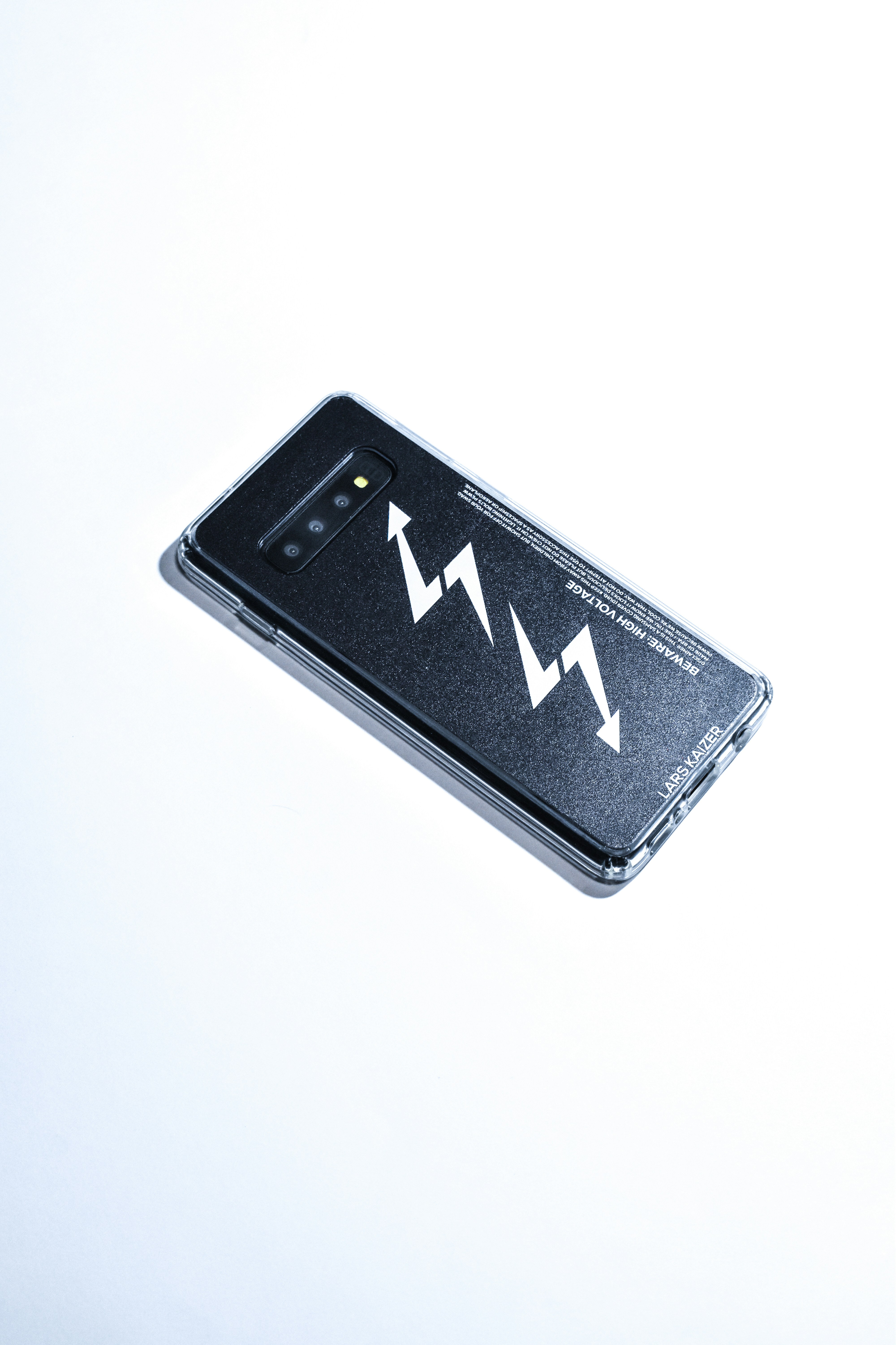 A smartphone with a striking black and white lightning bolt design, angled against a bright white background.
