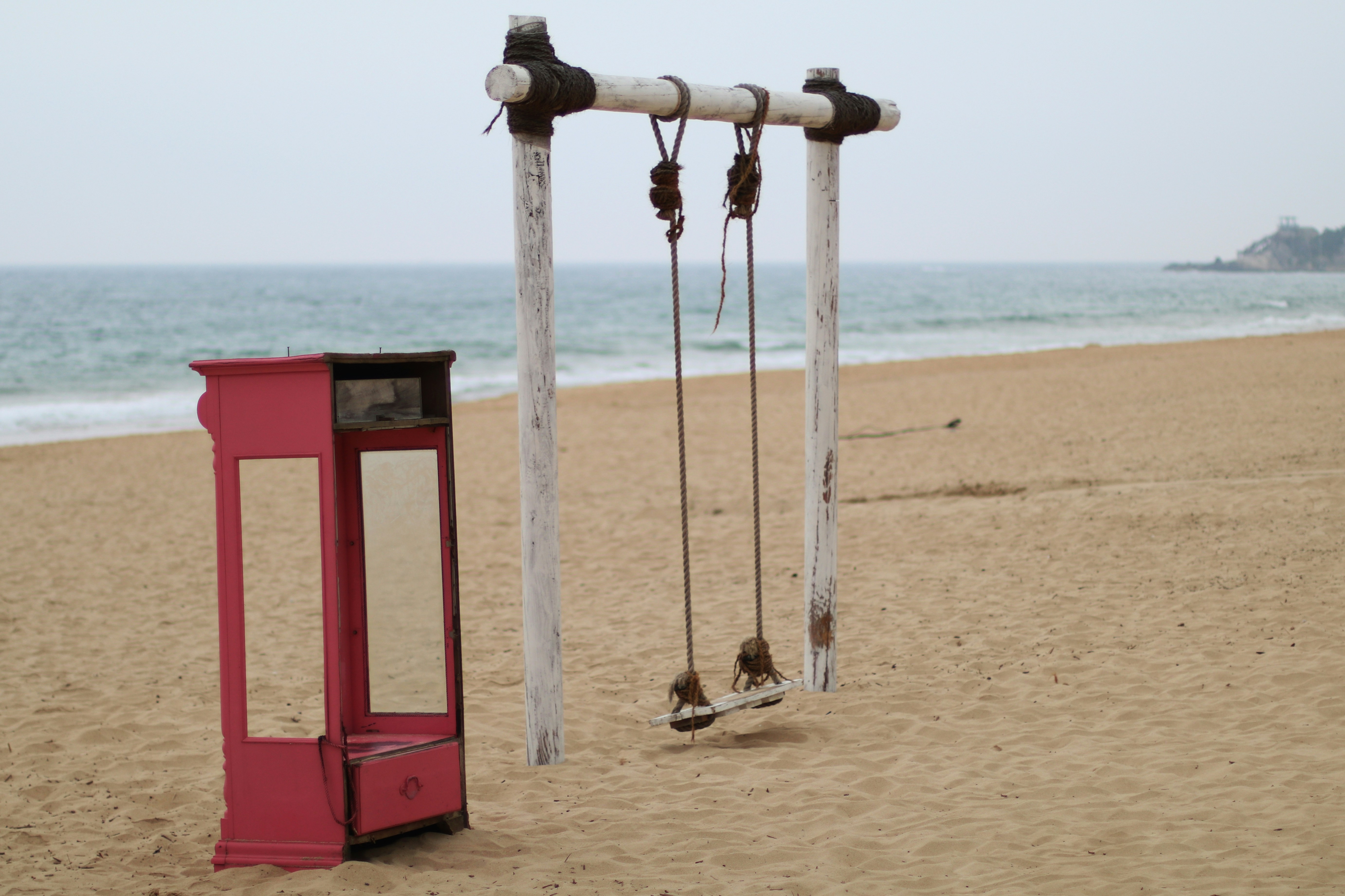 Dune Side: A Pink Cabinet and Weathered Swing Frame on Quiet Beach