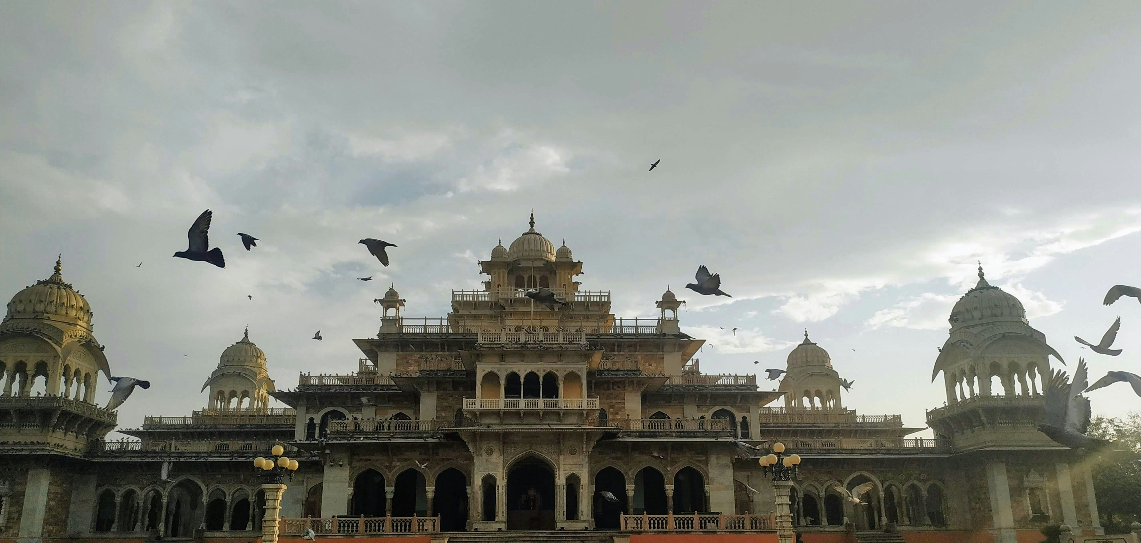 Crown of Arches: Palace Facade Under a Sky of Flocking Birds