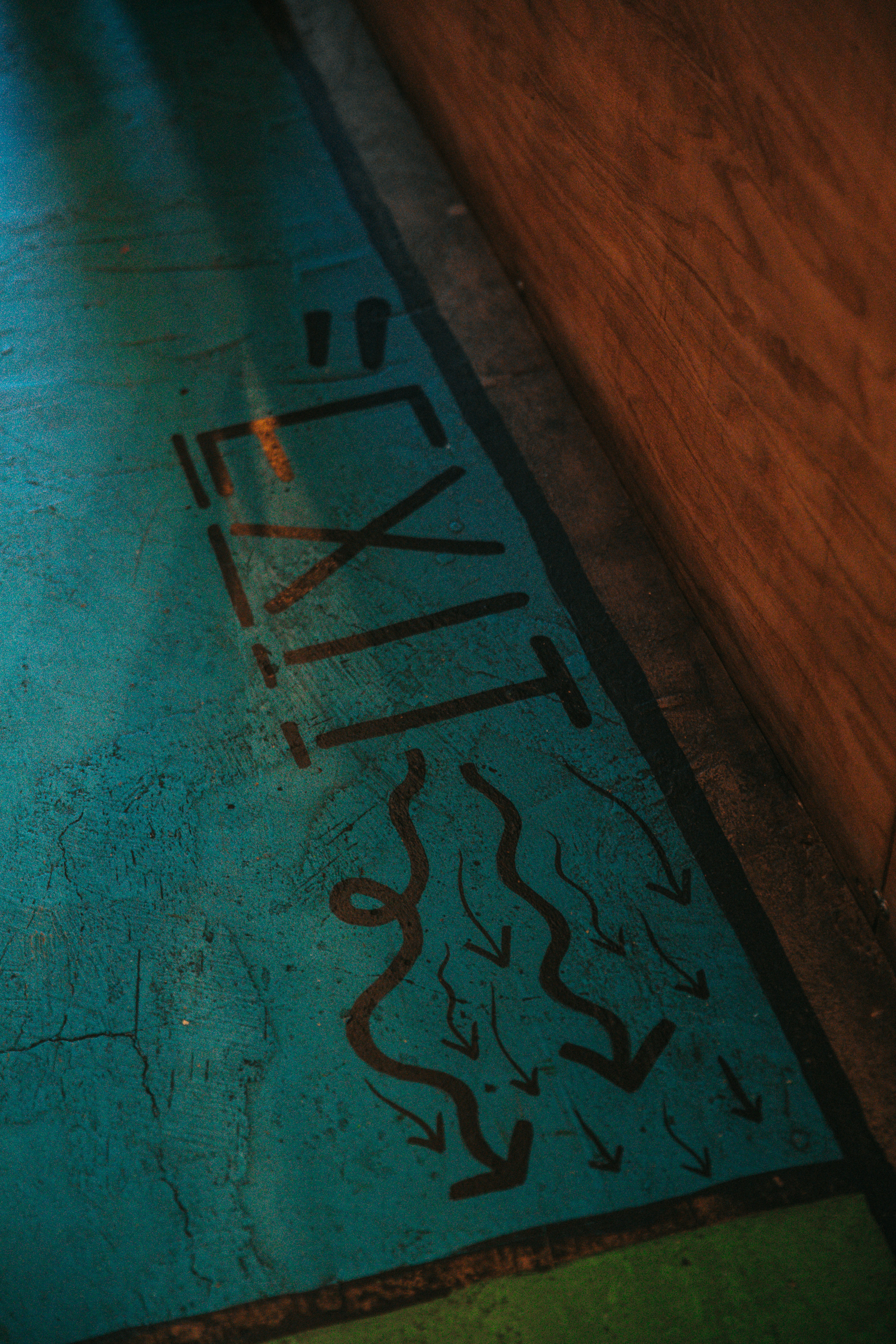 Aglow Sidewalk Glyphs: Neon Blue Beneath the Orange Riser