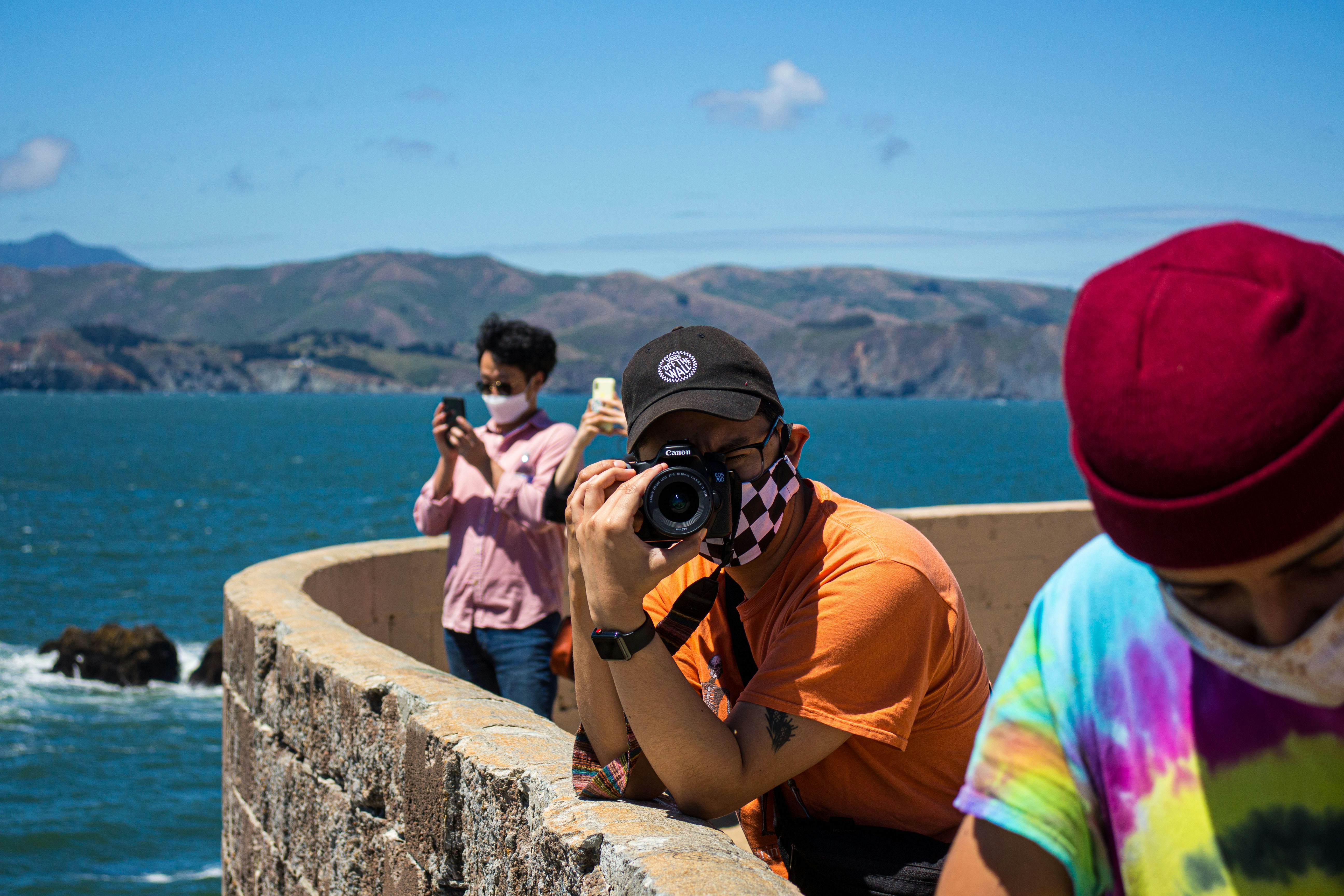 Photographers on a seaside overlook capture the scene