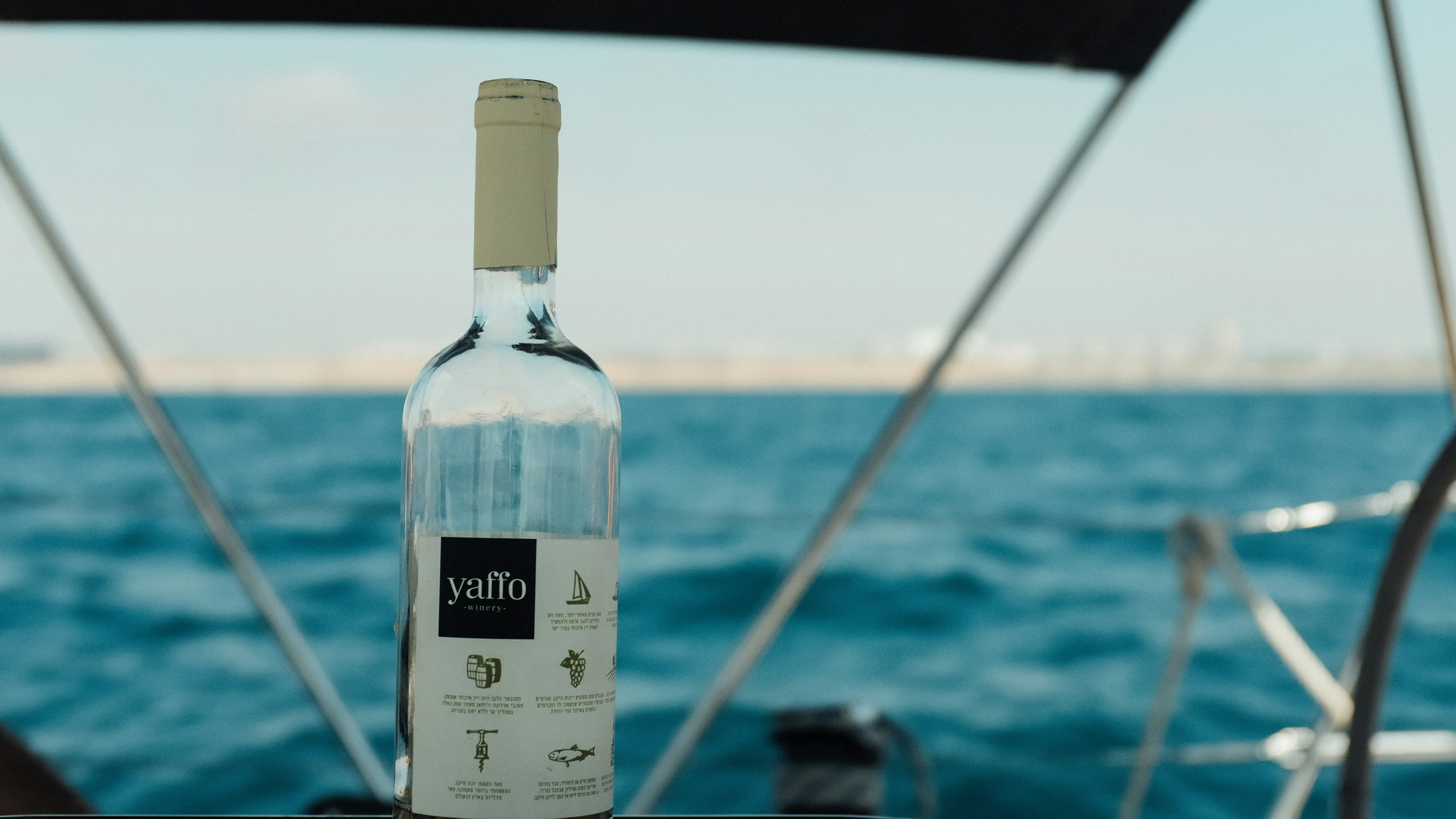 Yafo on the Deck: A Bottled Moment Framed by Waves and Rigging
