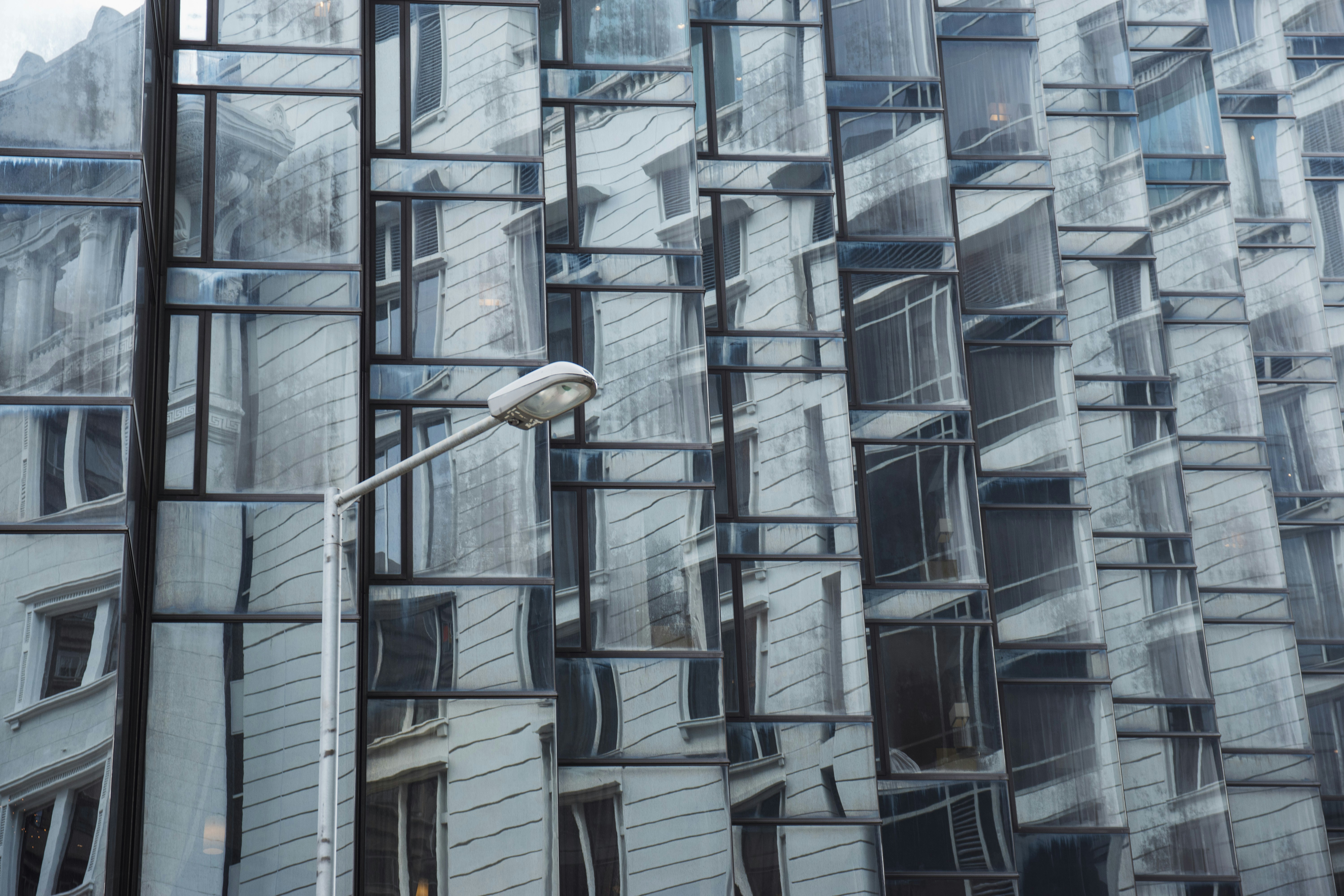 Facade of Reflections: a Streetlamp Adrift in a Glass Mosaic
