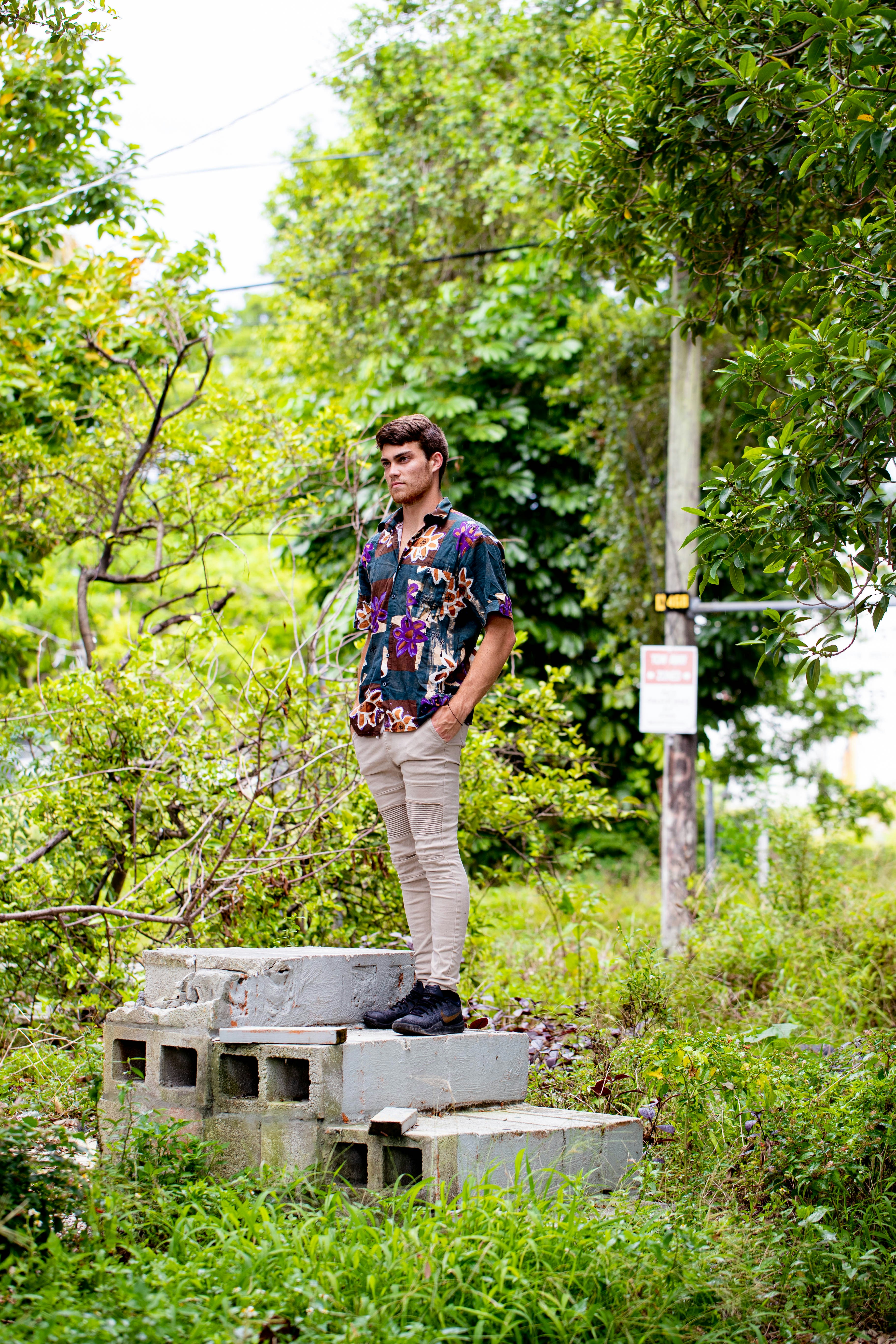 Elevated Poise: Portrait on Concrete Blocks Surrounded by Foliage