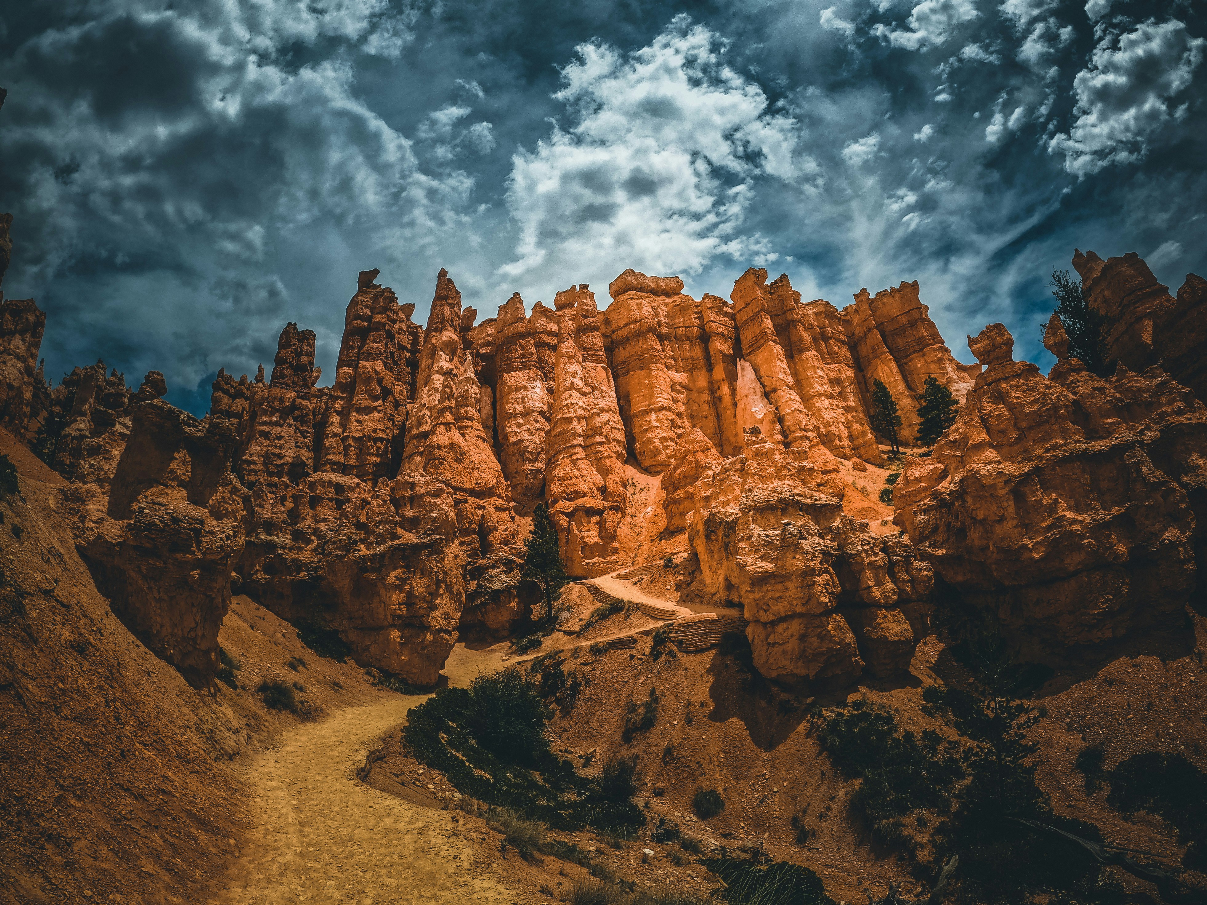 Towering red rock formations under a dramatic cloudy sky.