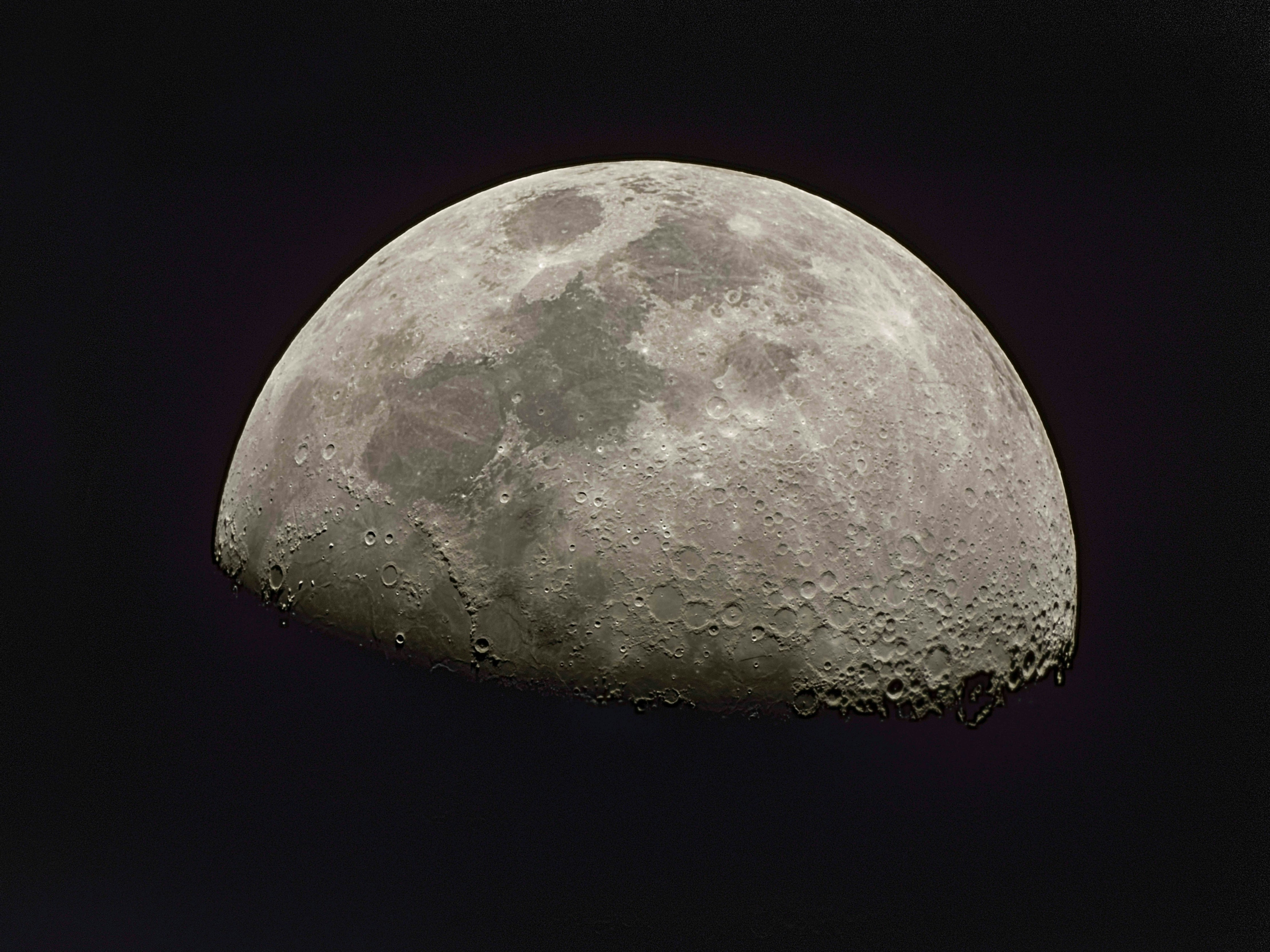 Detailed view of the moon showcasing its cratered surface and distinct features against a dark backdrop.
