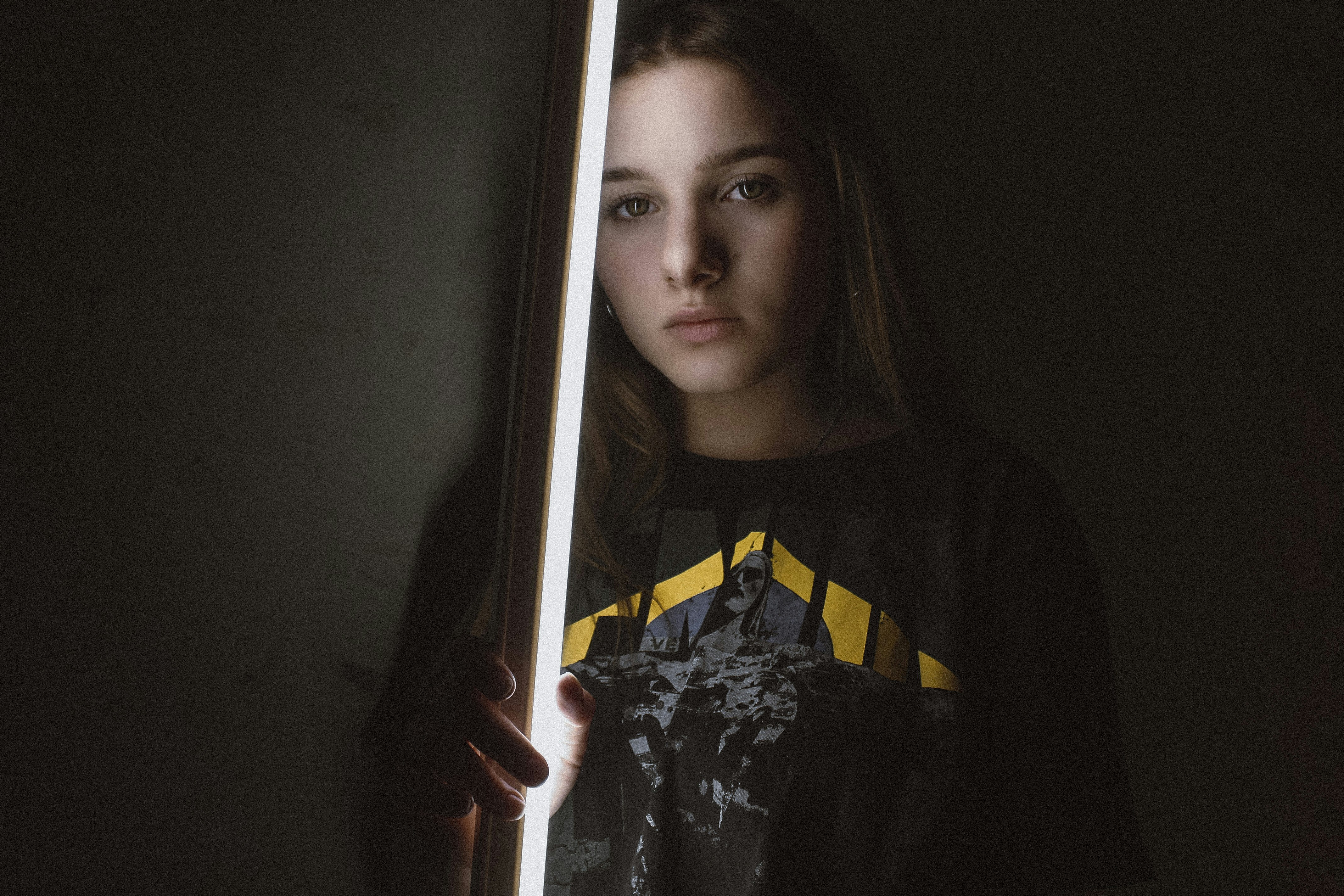 Threshold Glow: A Quiet Portrait Framed by a Single Light Strip