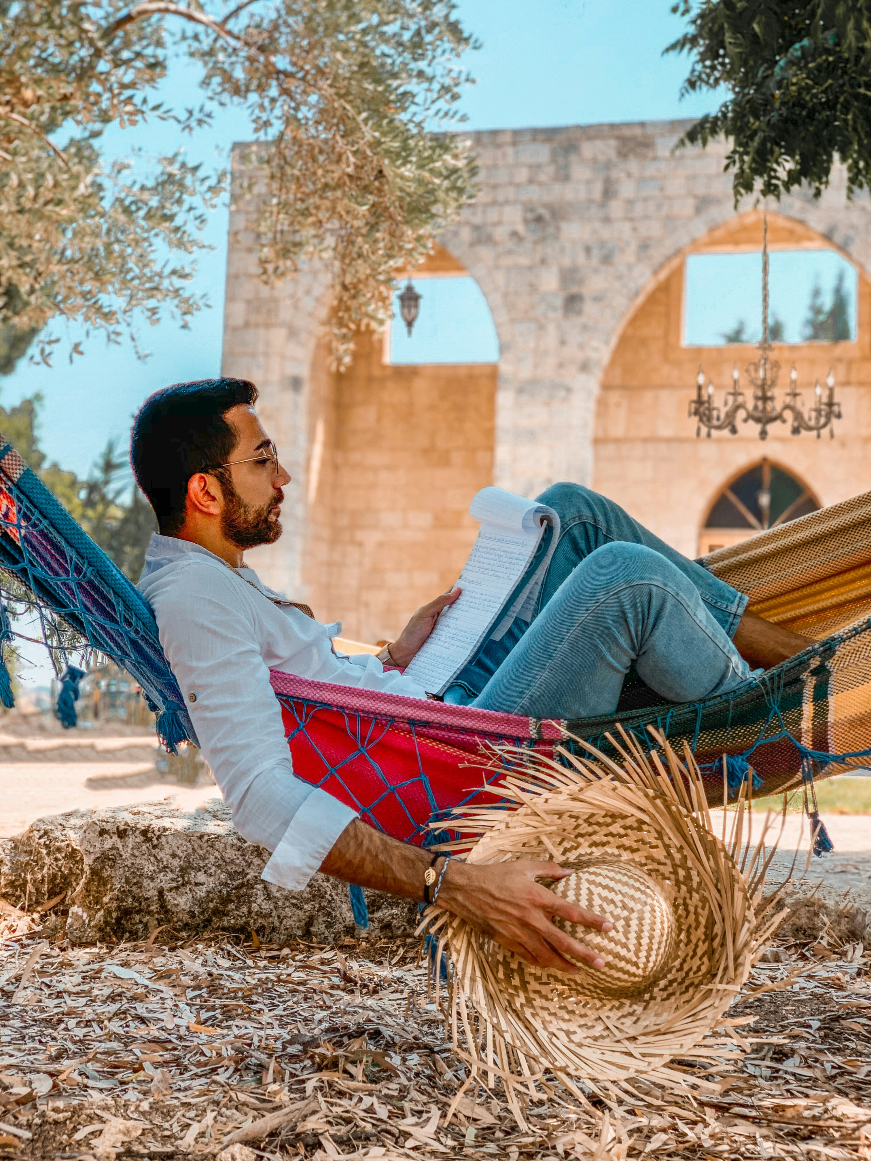A Quiet Reader Reposes in a Hammock Beneath Sunlit Arches