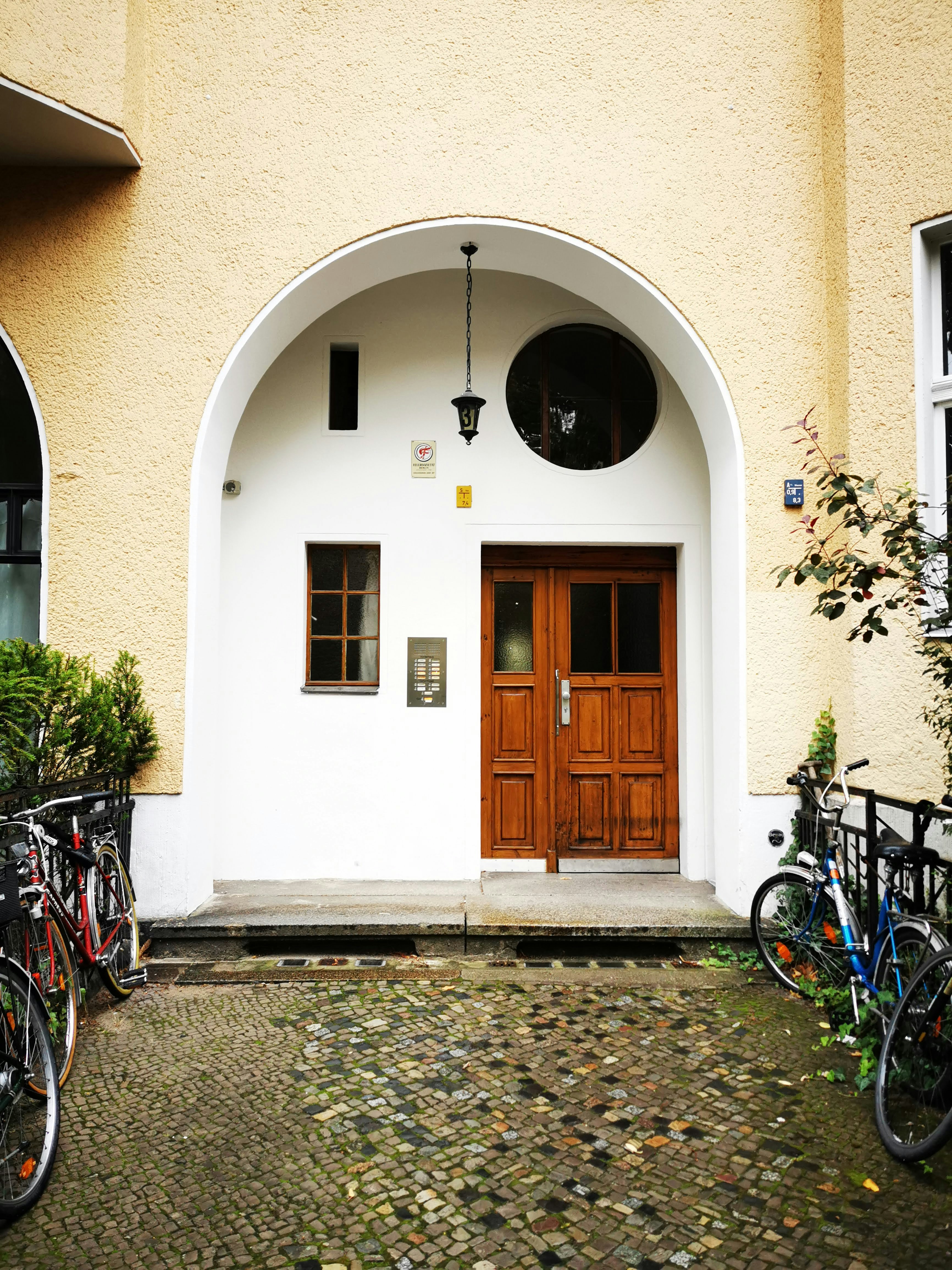 Arched Entrance with Warm Wooden Doors under a Round Window
