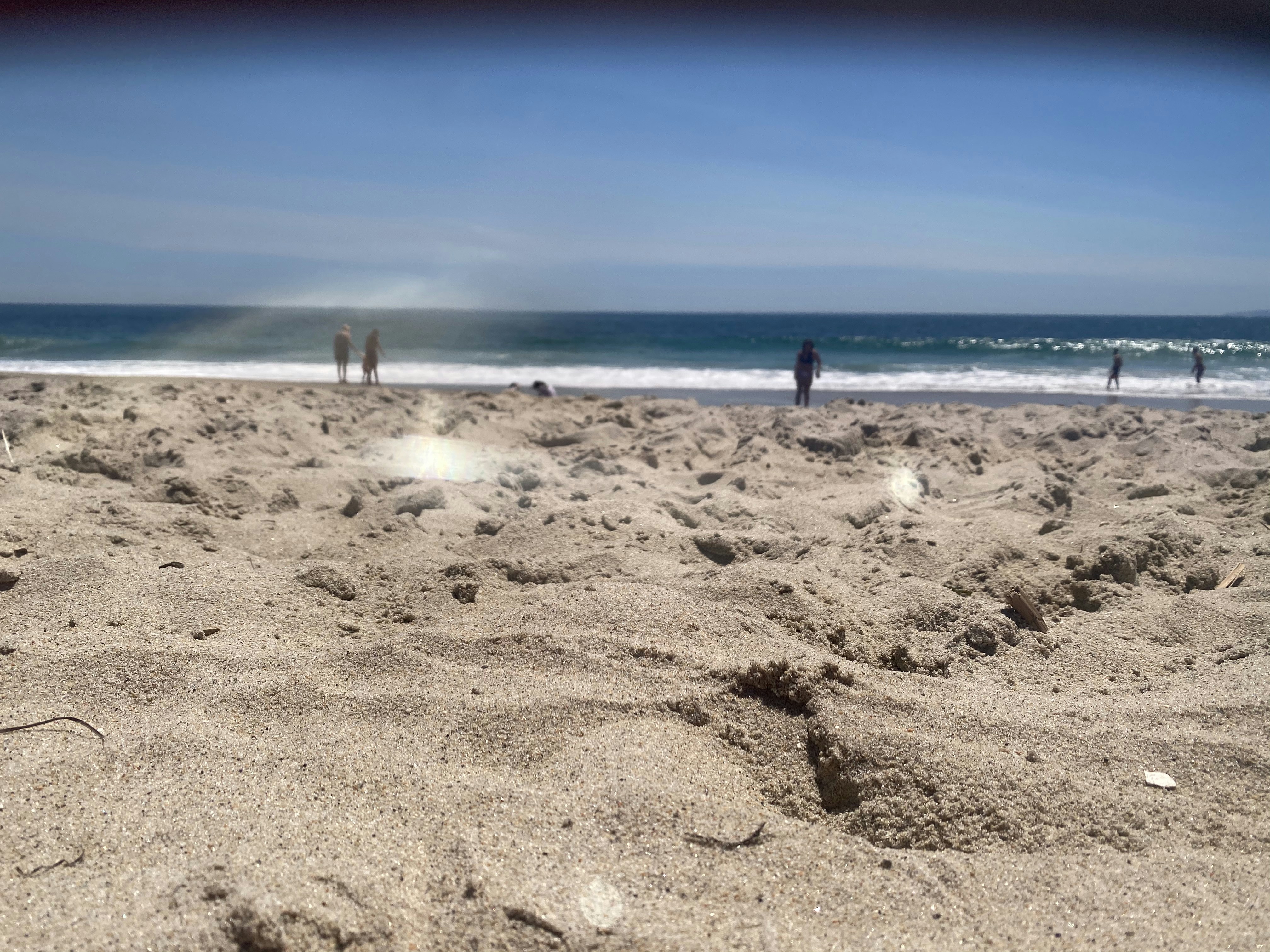 Tideline Footprints: A Sunlit Beach Composition