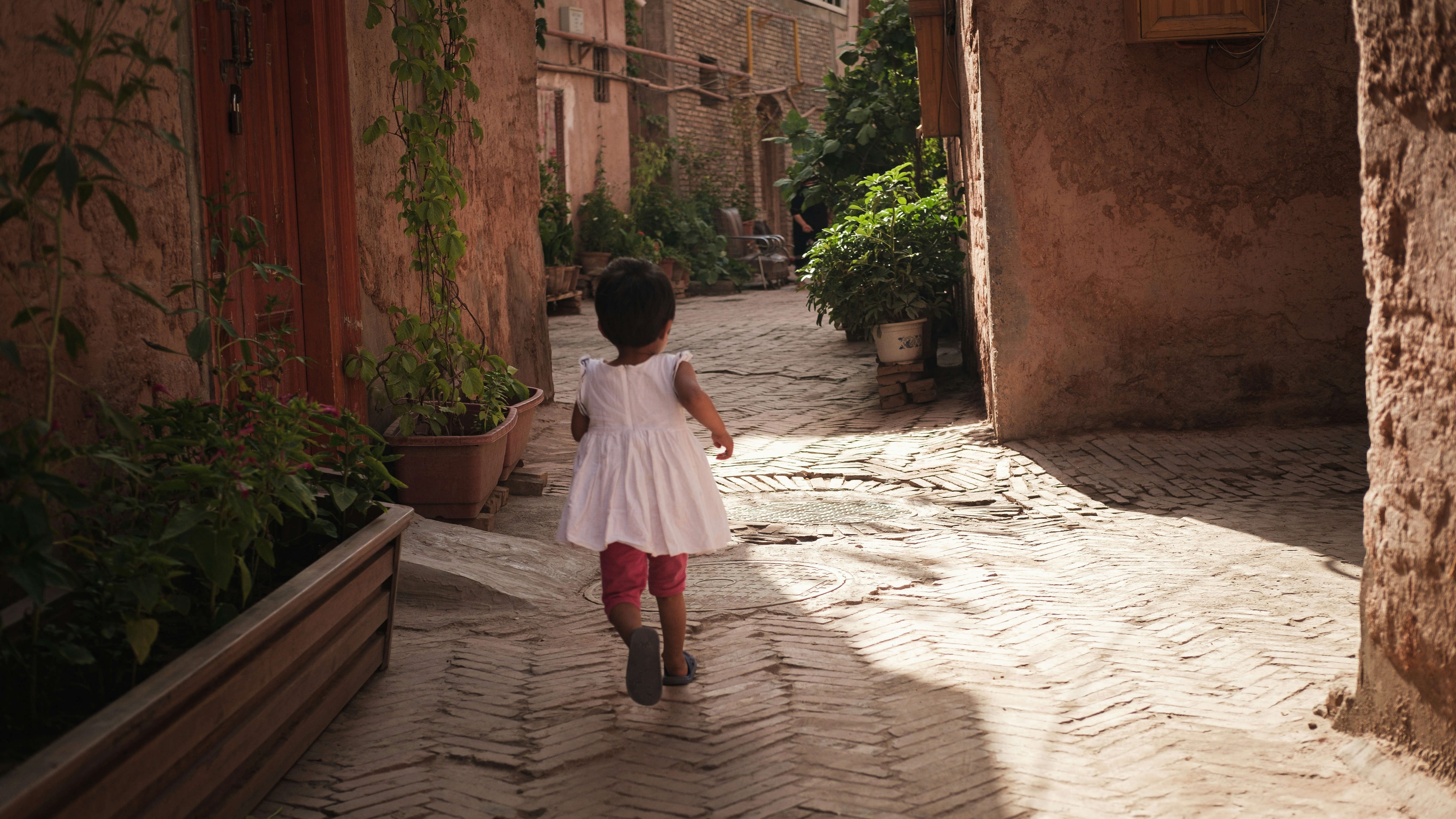 Sweet Determination: A Little Runner in a sunlit Alley