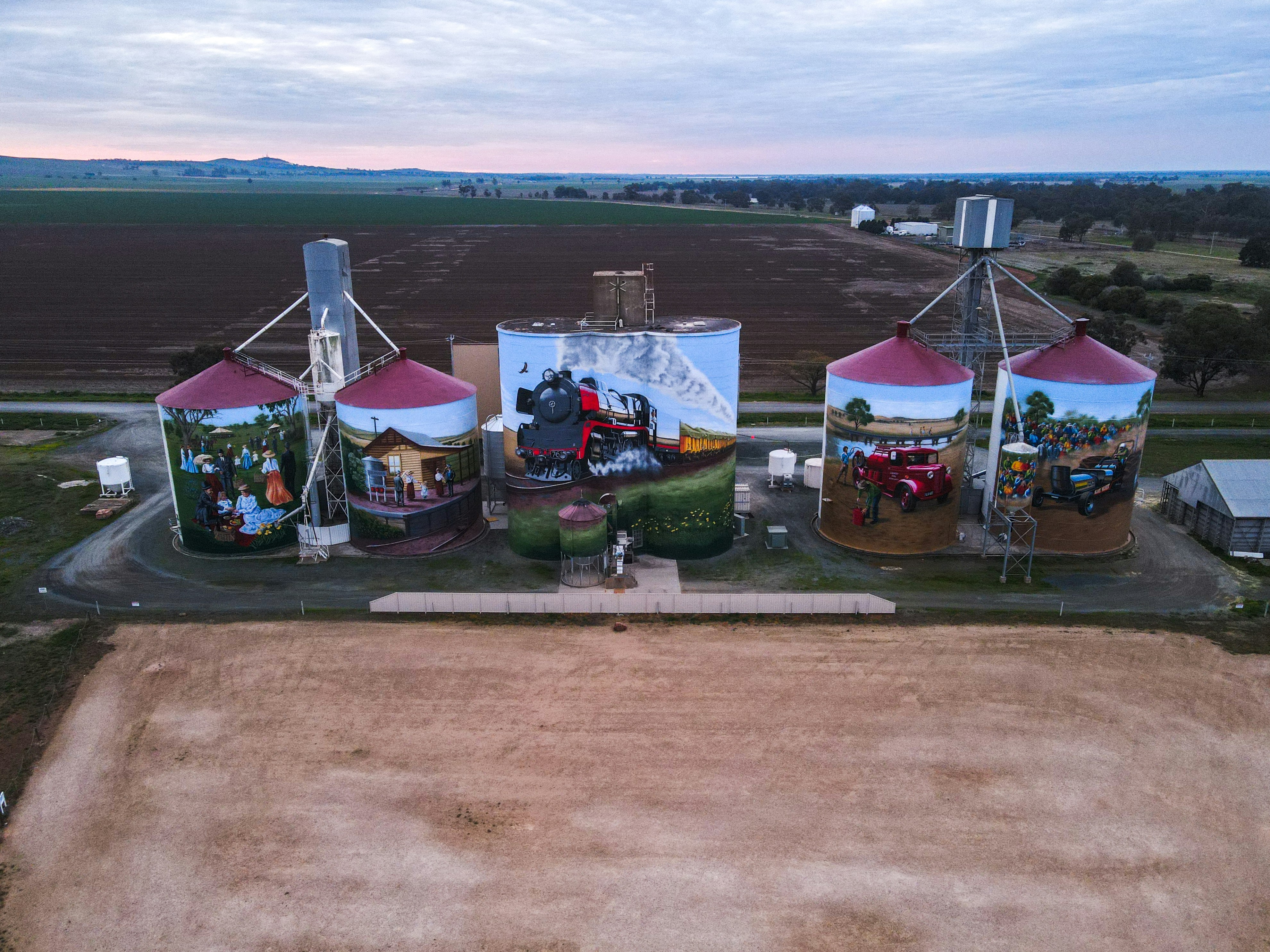 Silo Gallery: a Row of Painted Grain Silos Standing Guard Over Flat Farmland