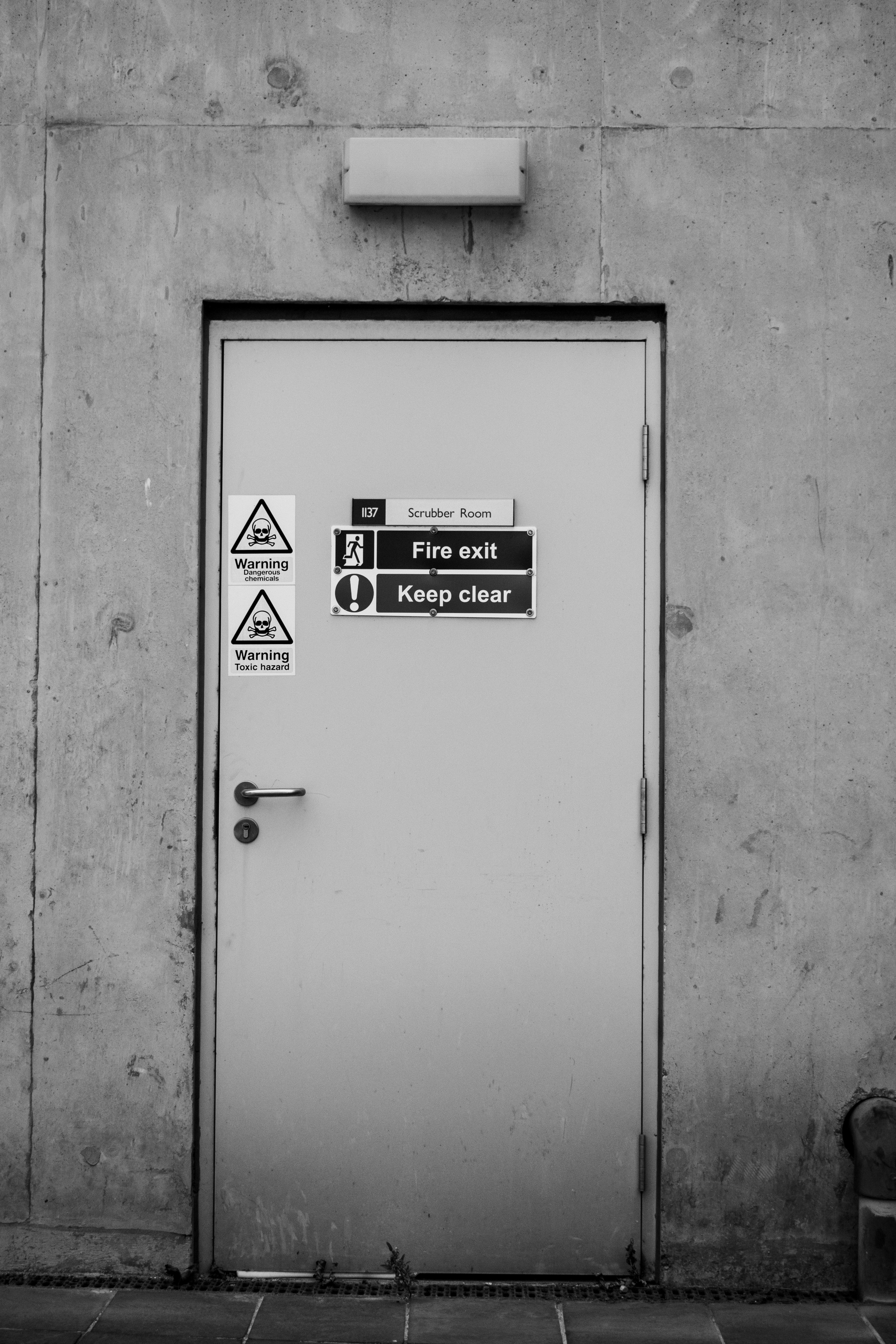 Industrial Door with Hazard Signage in Concrete Wall