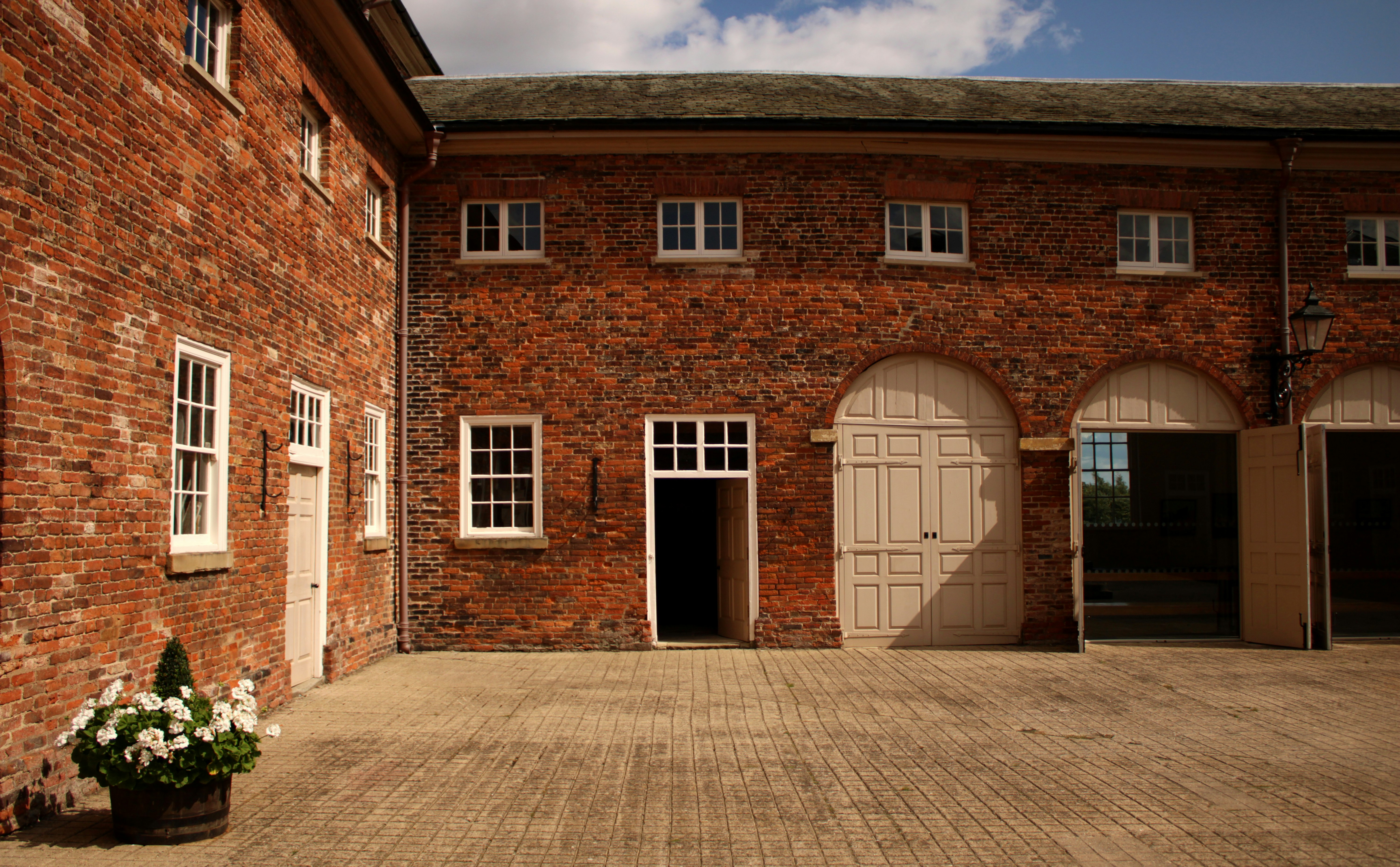 Brick Courtyard: Sunlit Archways and Open Doorways