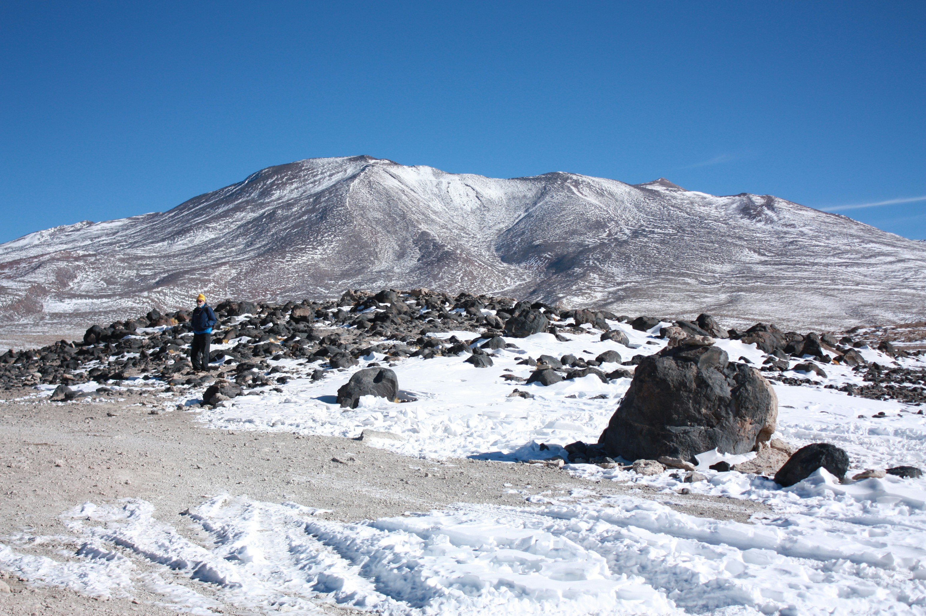 people on snow covered field near mountain under blue sky during daytime