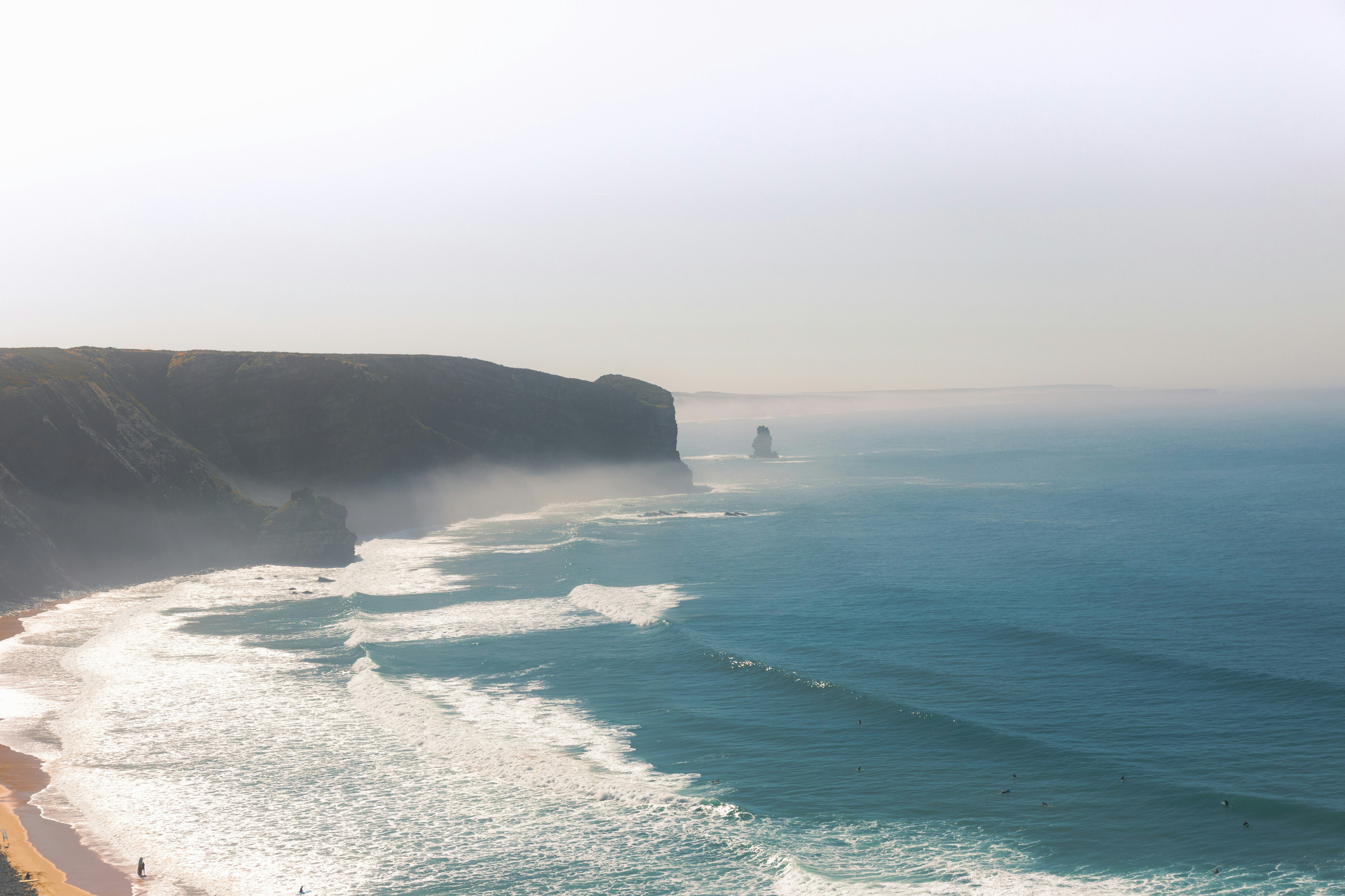 Edge of Daybreak: Mist Licks the Cliffs Over a Calm Atlantic