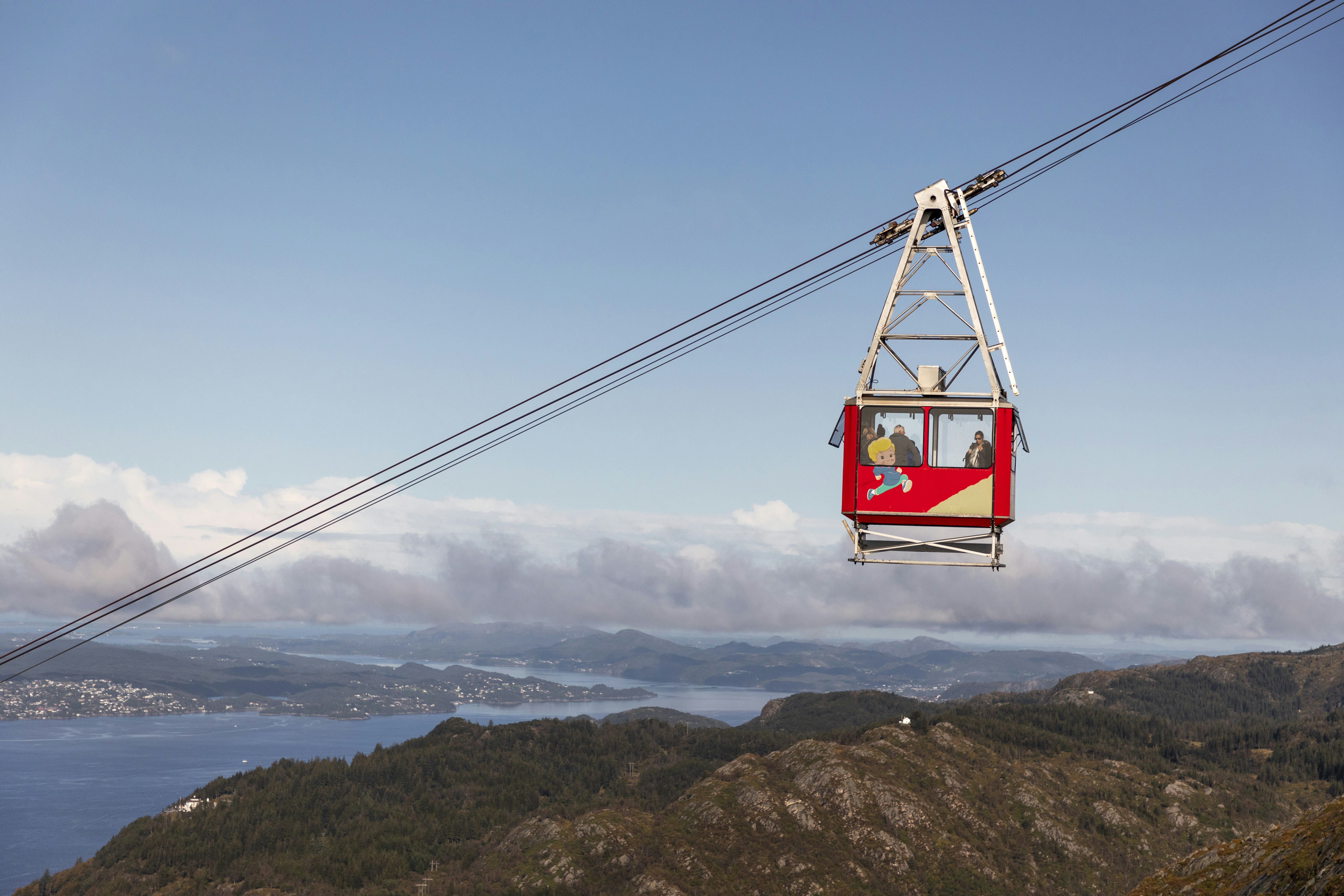 A Cablecar Cresting Over Oceanic Valleys at Sunset