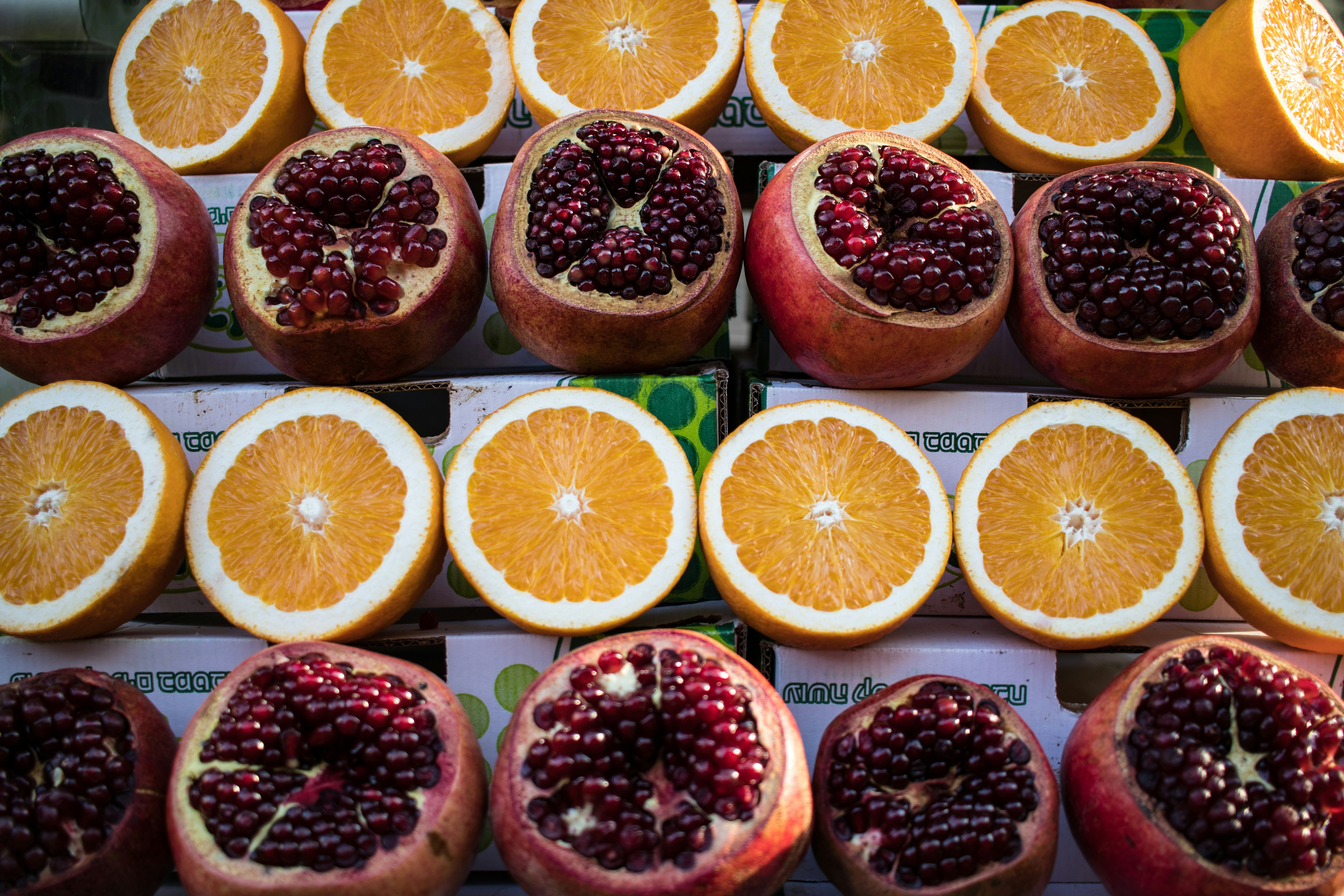 Grid of citrus and ruby seeds: a precise still-life of oranges and pomegranates
