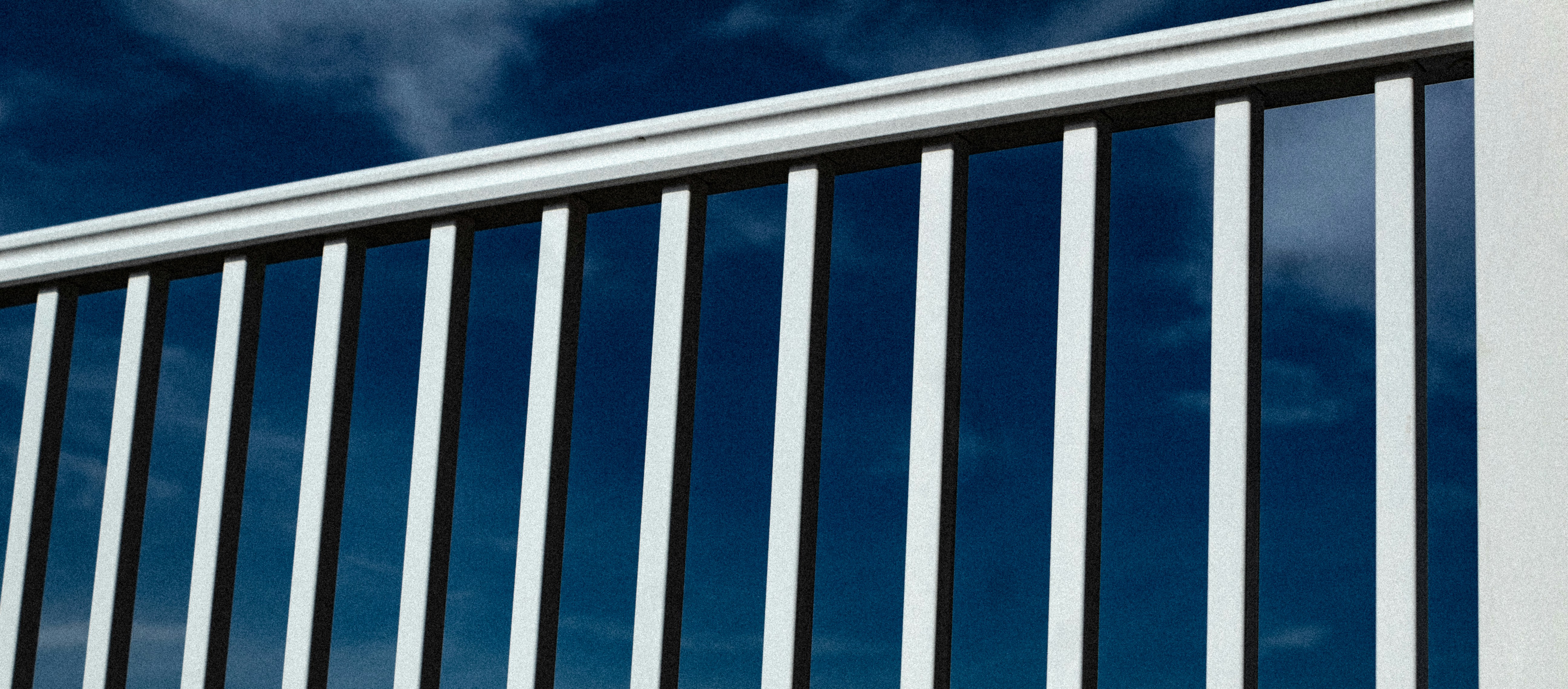 white and blue striped metal railings under blue sky