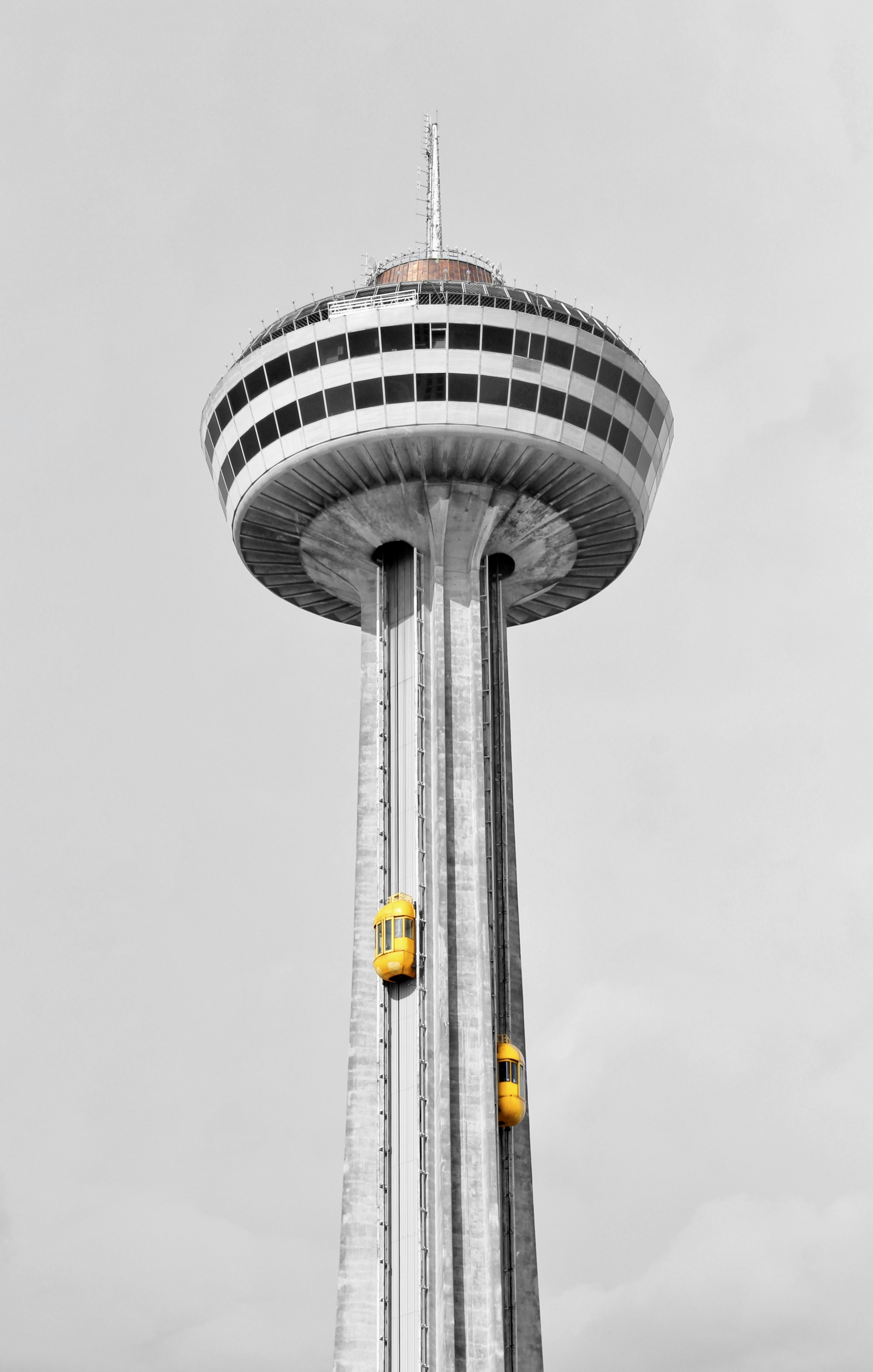 Two Yellow Pods Cling to a Towering Spire: A Minimalist Skyward Study