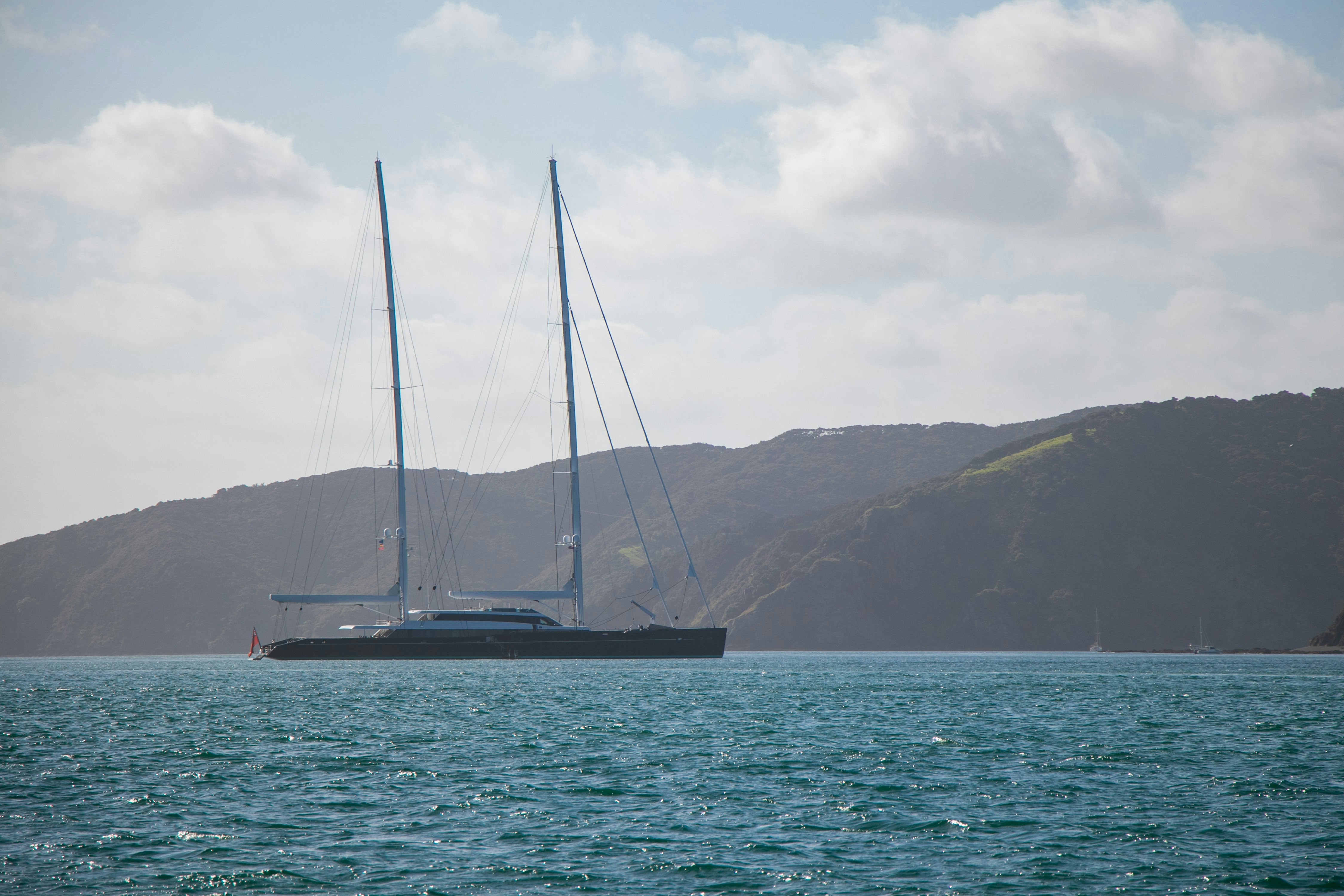 Twin-Masted Sailboat at Turquoise Bay, Framed by Emerald Cliffs