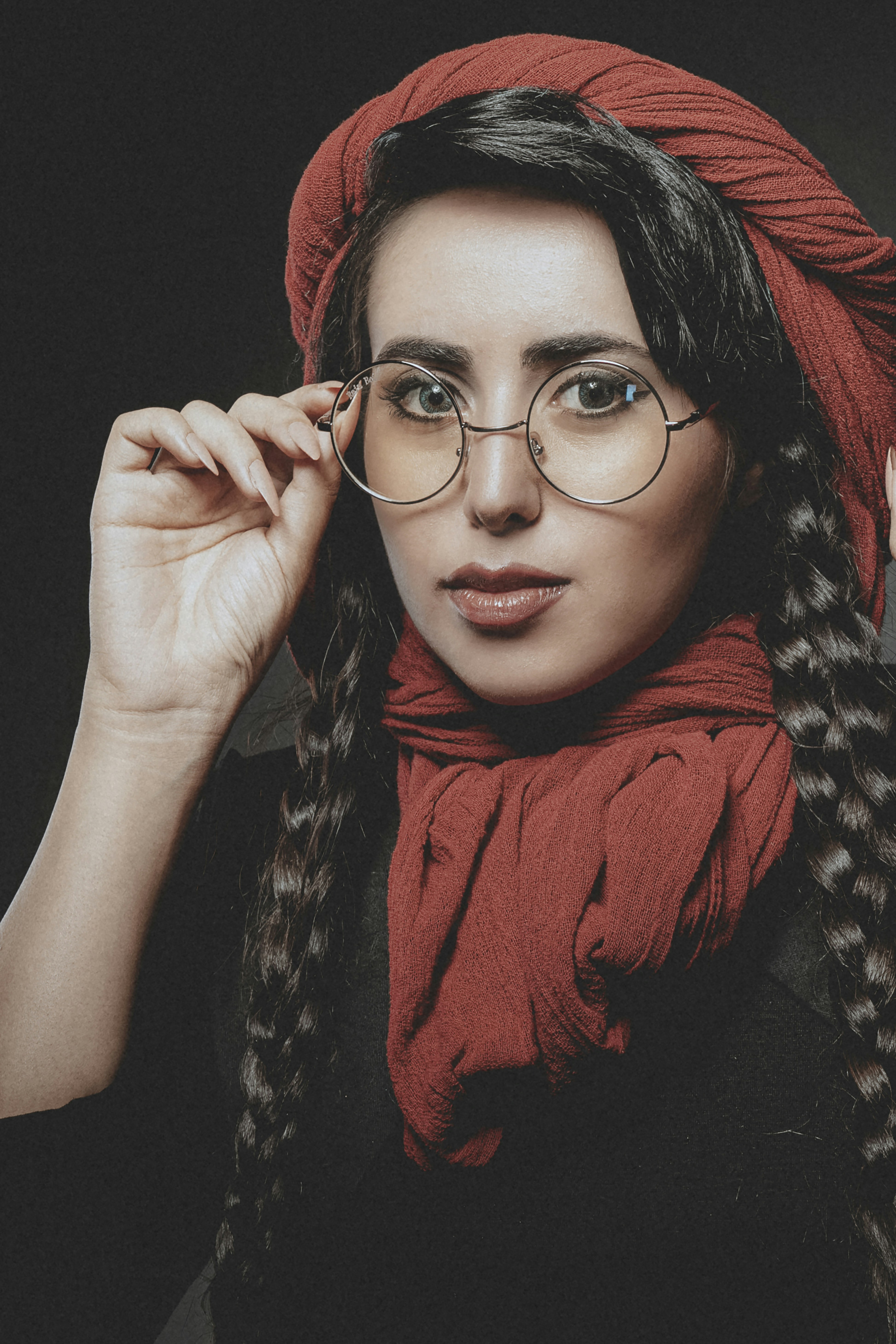 Crimson Gaze in Round Glasses: A Poised Studio Portrait