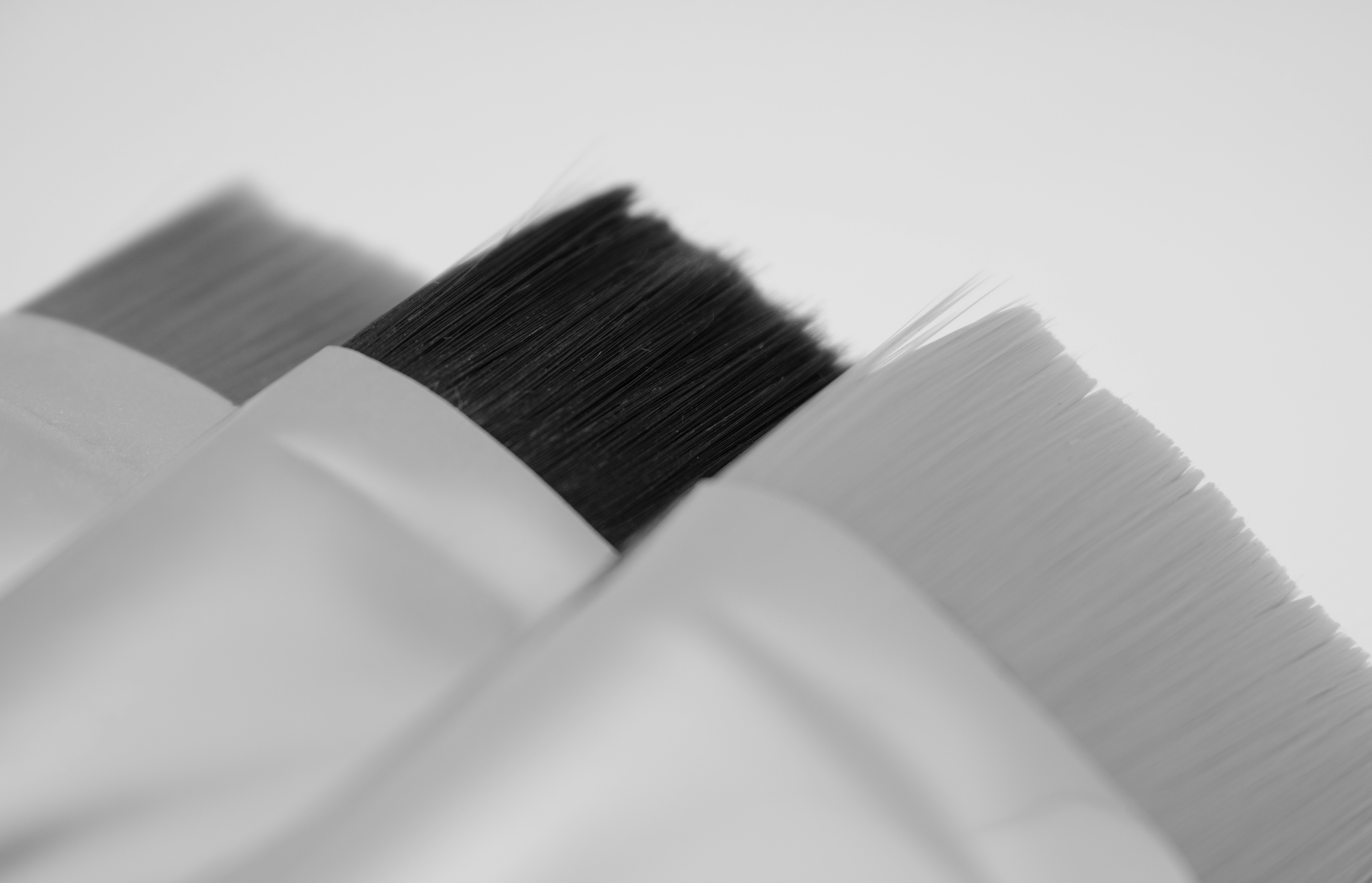 Brushstrokes of Light: A Close-Up of Paintbrush Tips in Shadowed Overlap