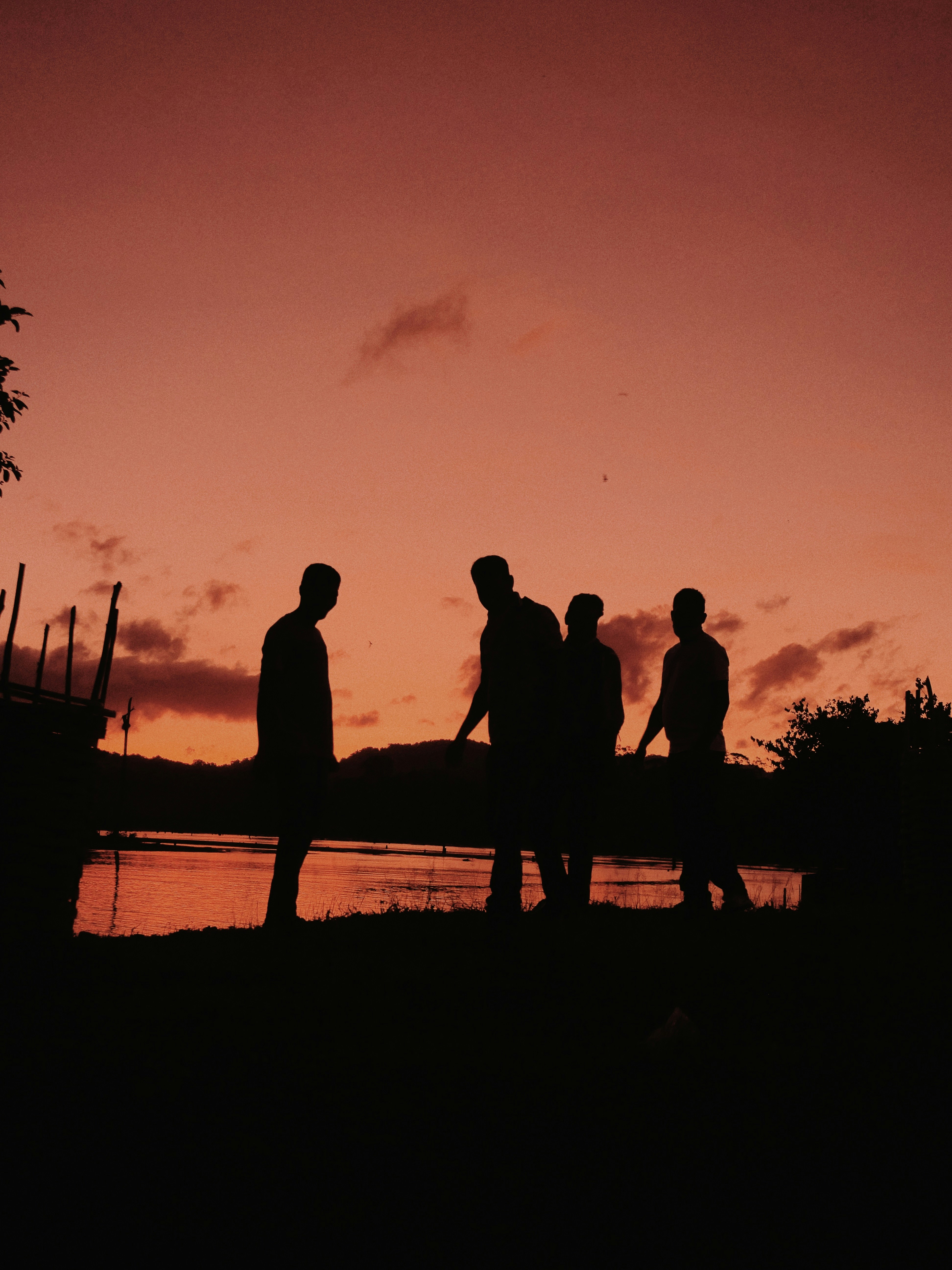 Crimson Dusk: Five Silhouettes Gather by the Riverside