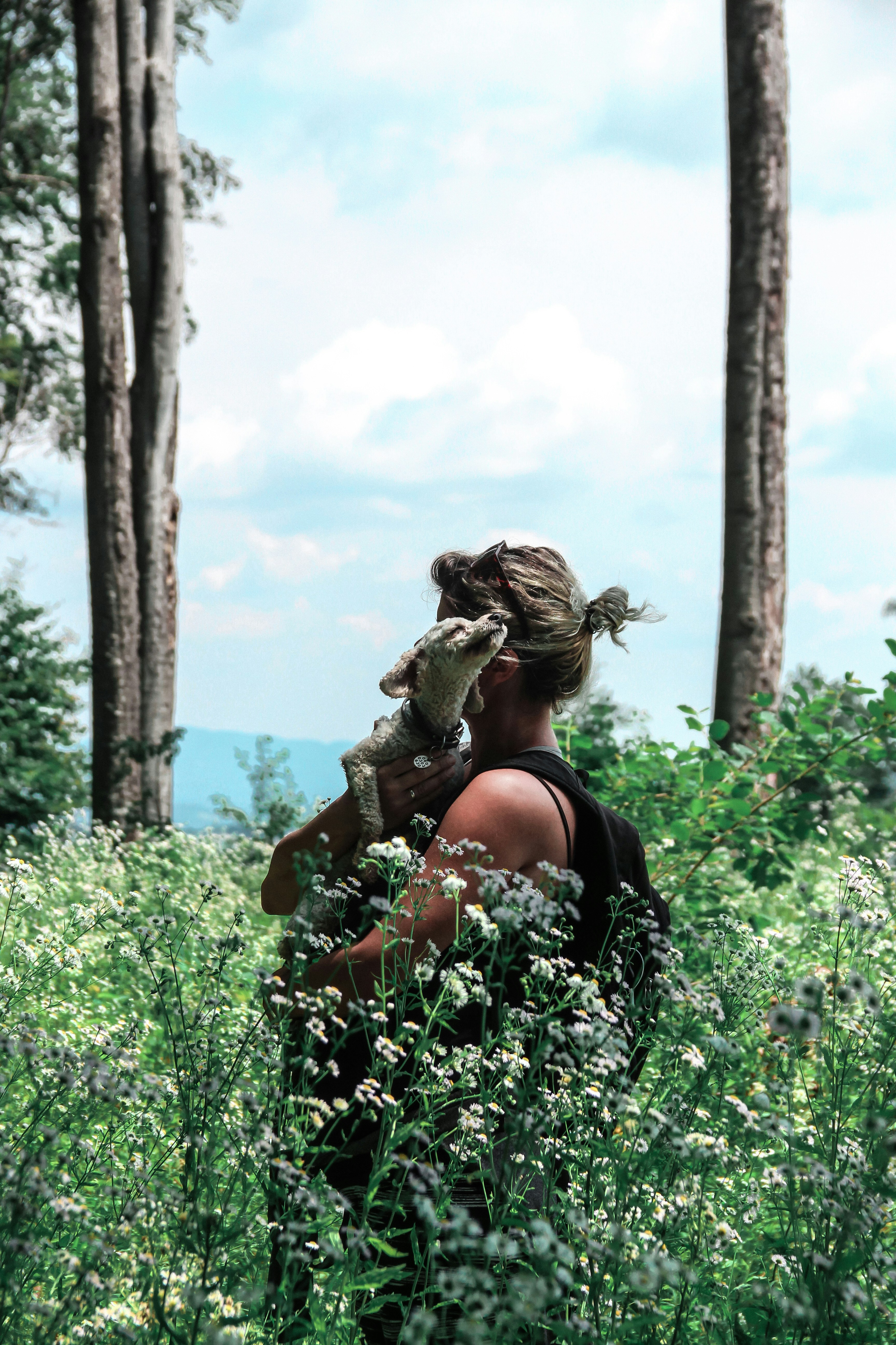 Fieldbound: Quiet Portrait of a Woman and Her Dog Amid White Wildflowers