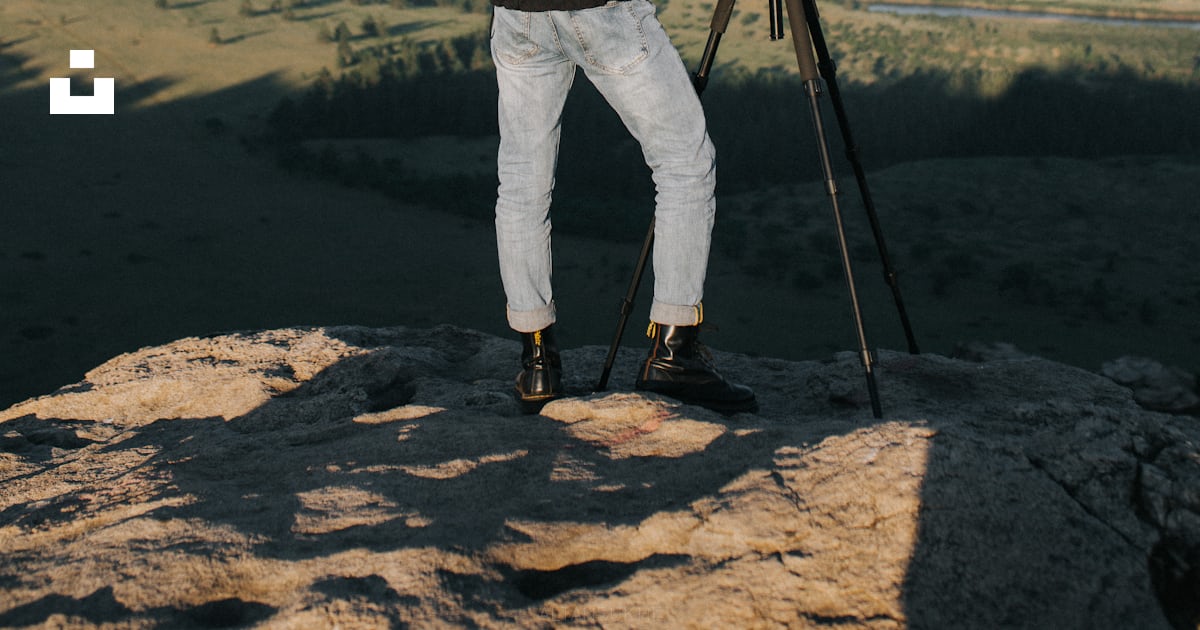Hombre Con Chaqueta Negra Y Pantalones Blancos Sosteniendo Una Cámara