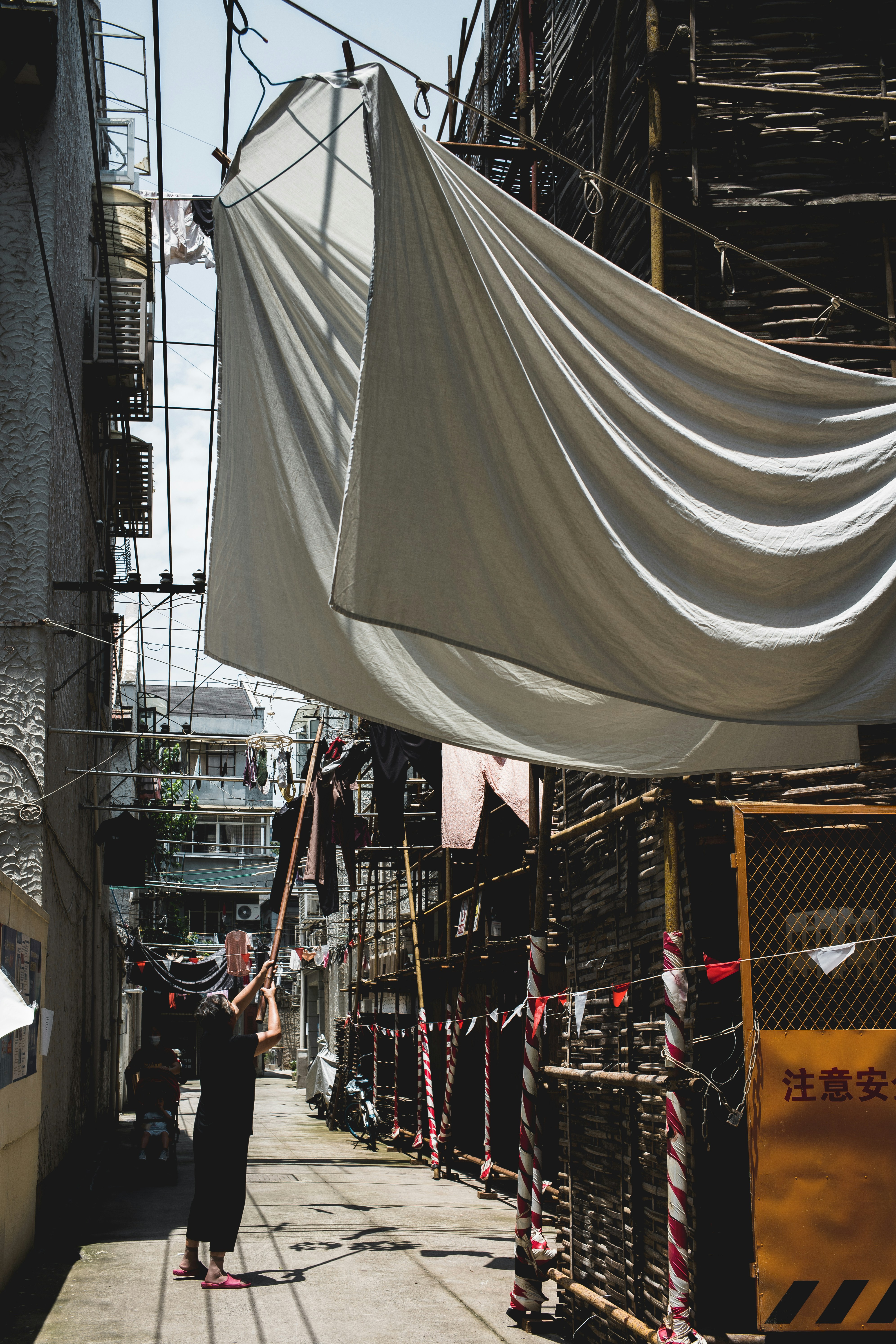 Laundry Canopy Over an Alley: Sunlit Drapes Framing Daily Life