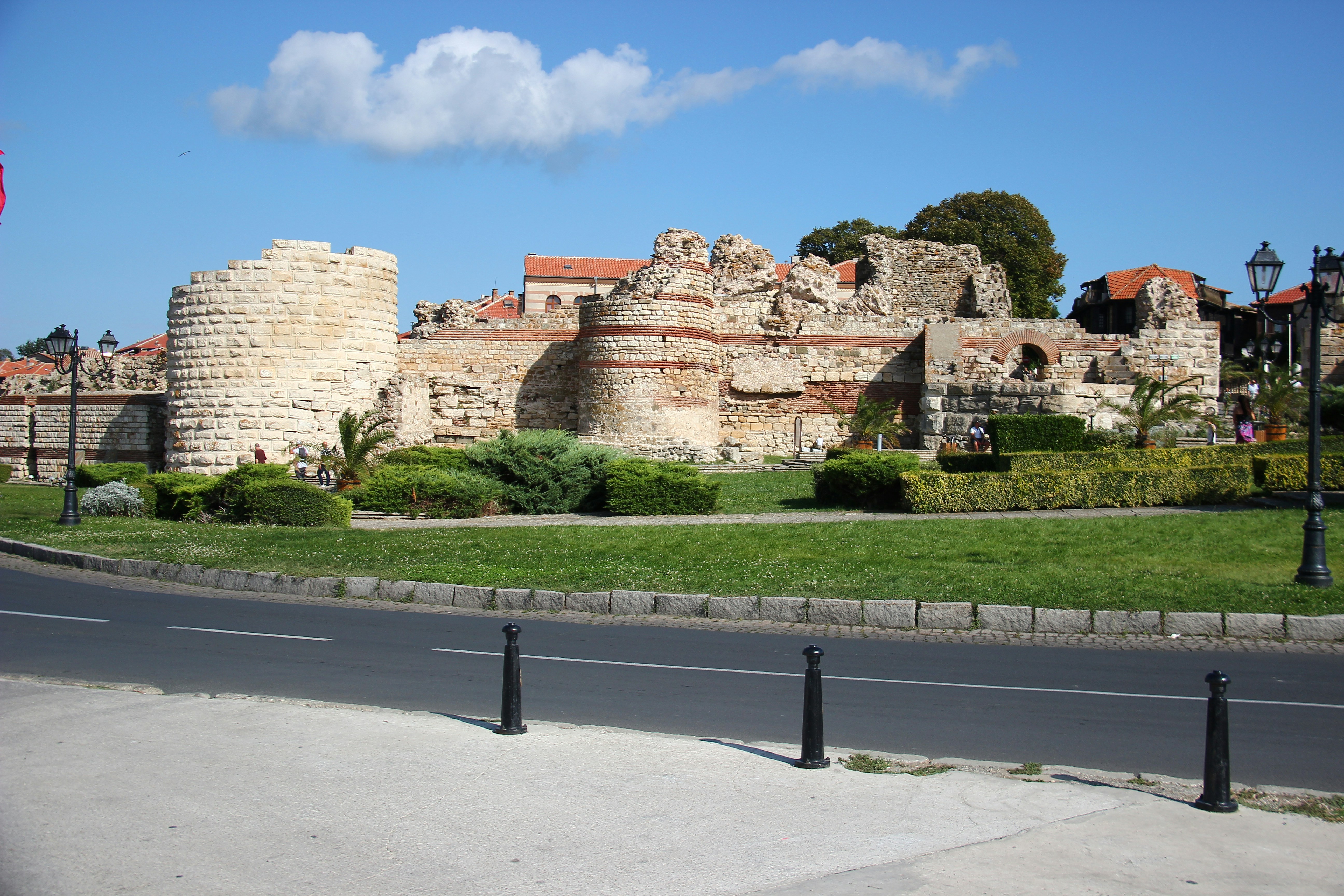 brown concrete building near green trees under blue sky during daytime