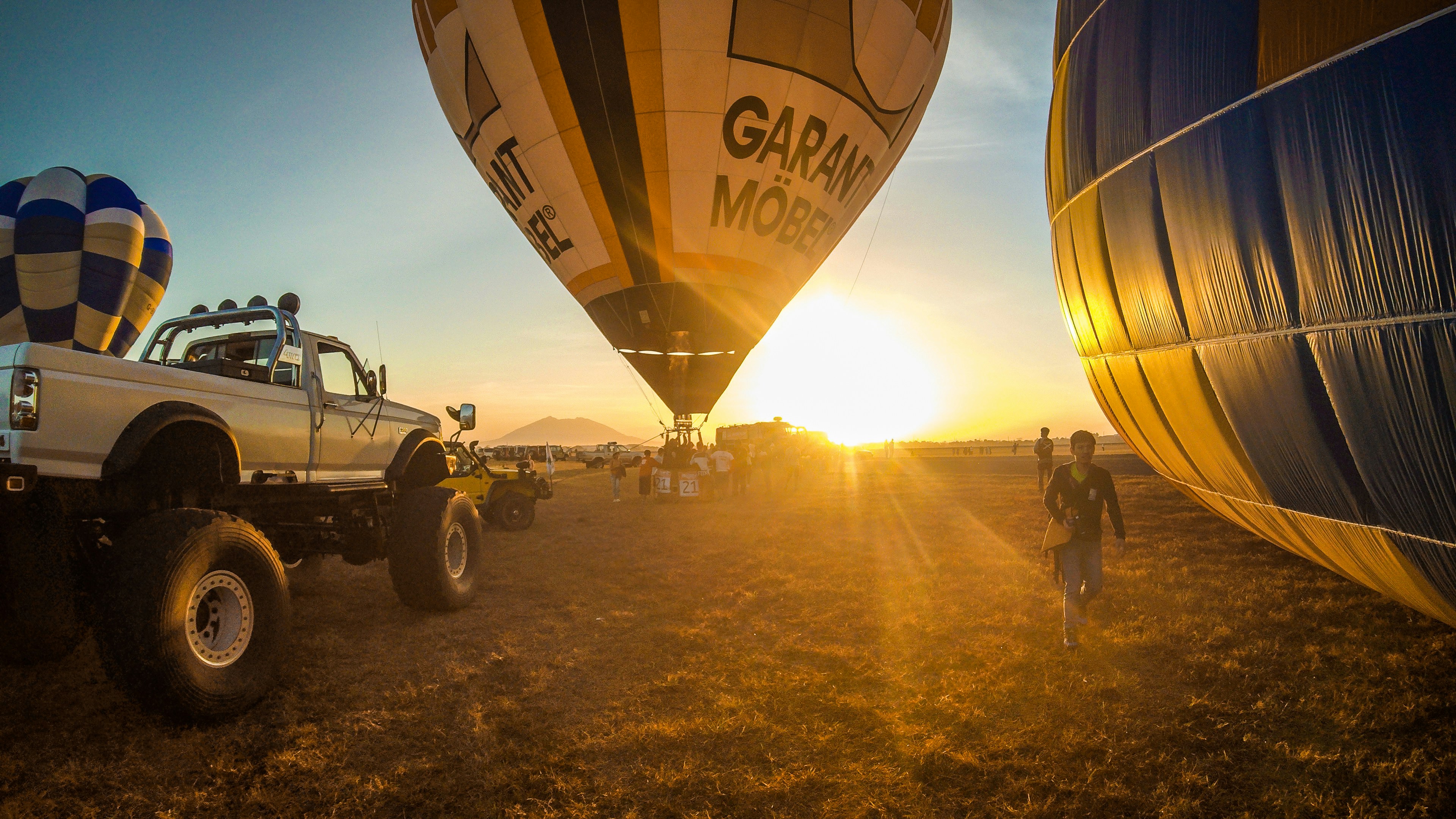 Hot Air Balloon Festival | people standing near hot air balloons during sunset