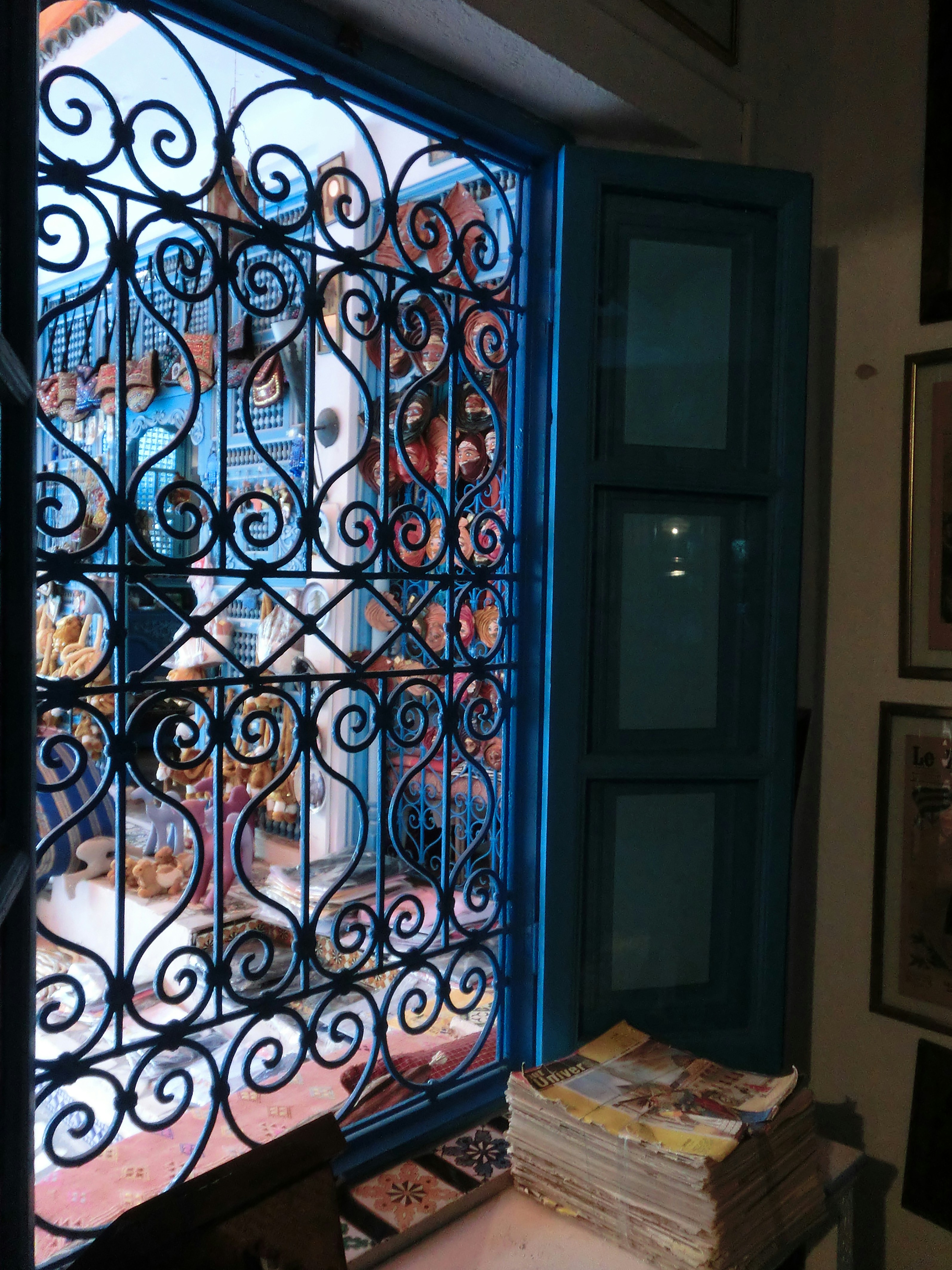 Cerulean Ironwork Gate Framing a Colorful Courtyard