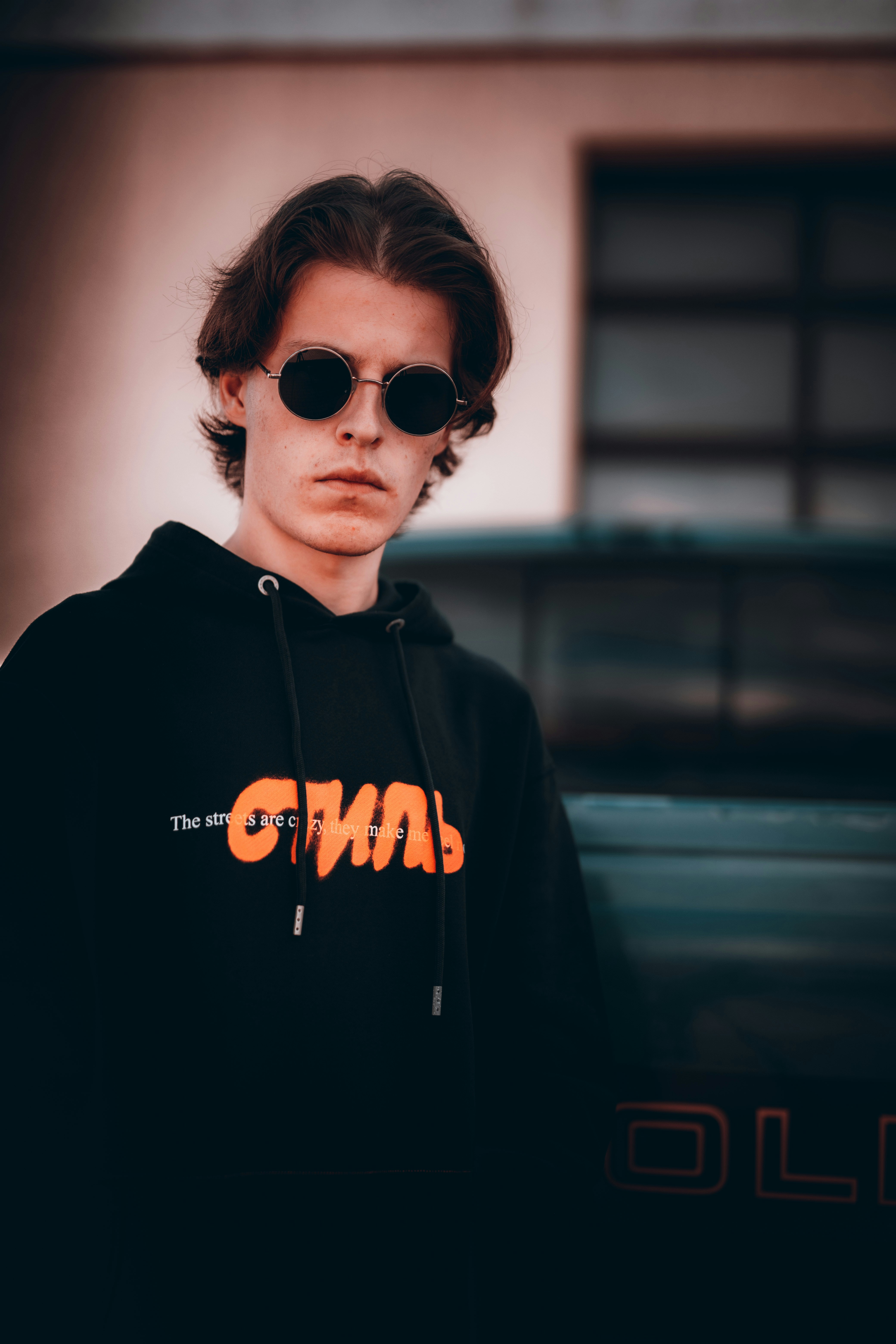 man in black hoodie wearing aviator sunglasses