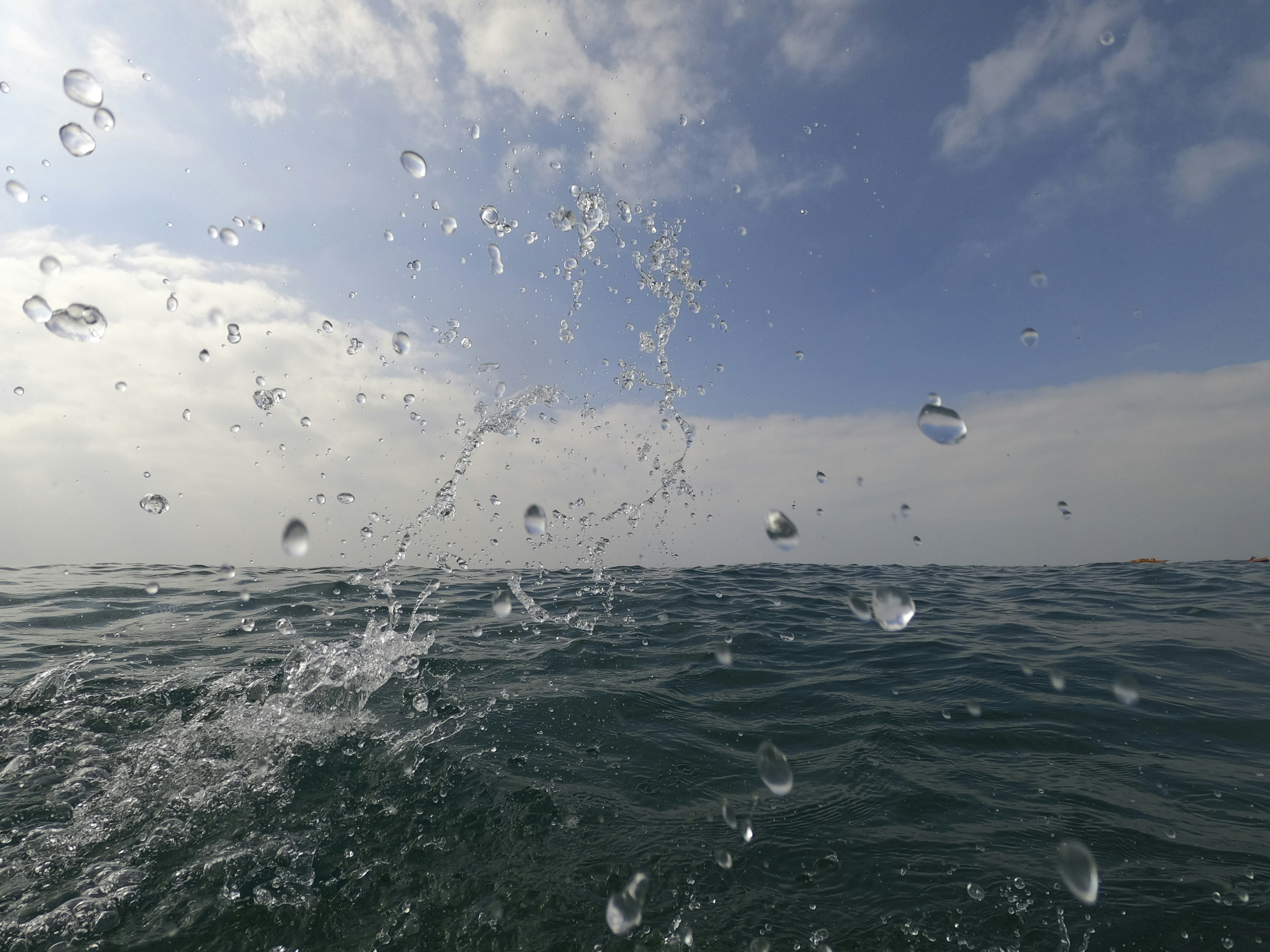 Splash Arc: Droplets Mid-Jump Above the Ocean