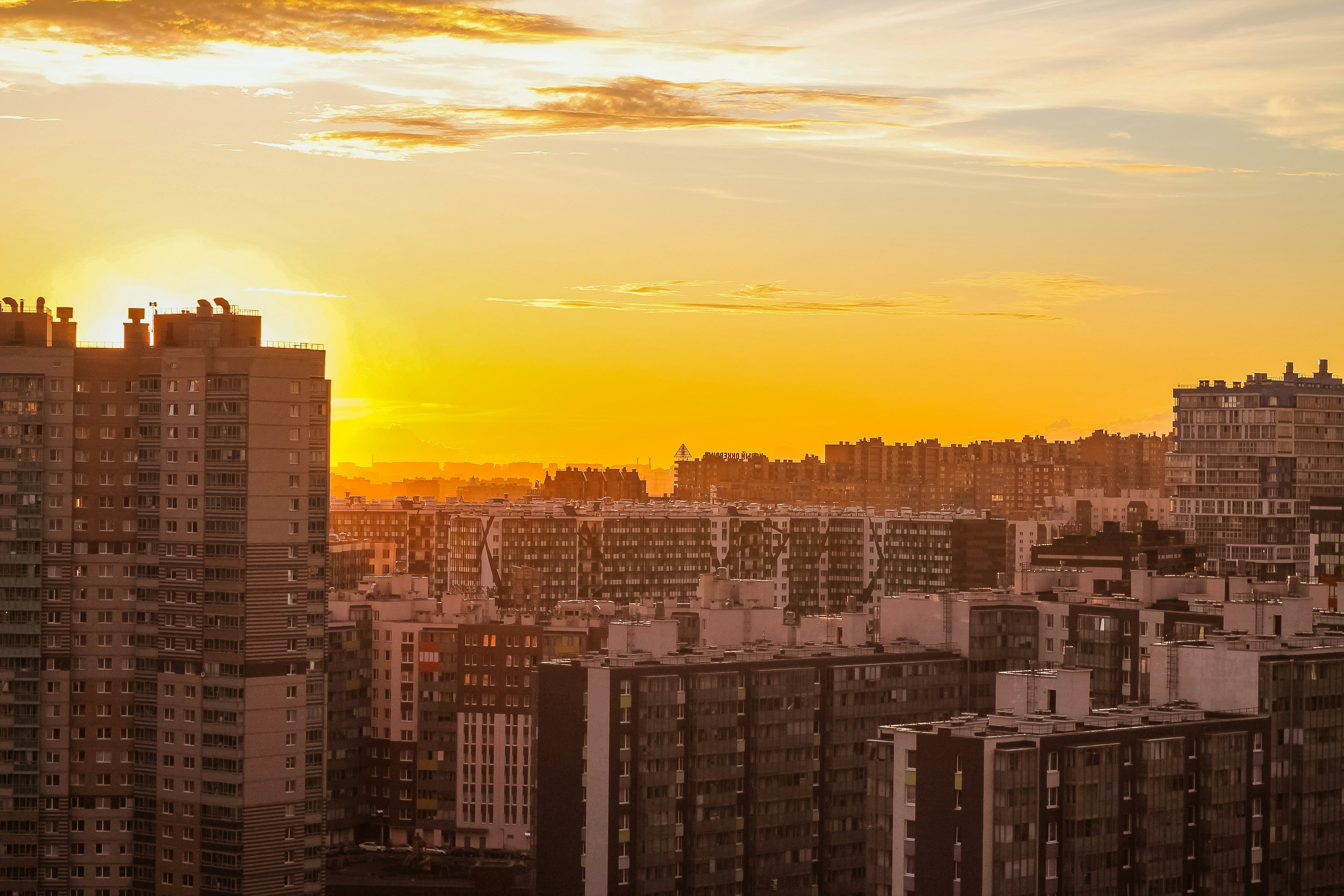 Sunrise casting a golden glow over city skyscrapers and rooftops.