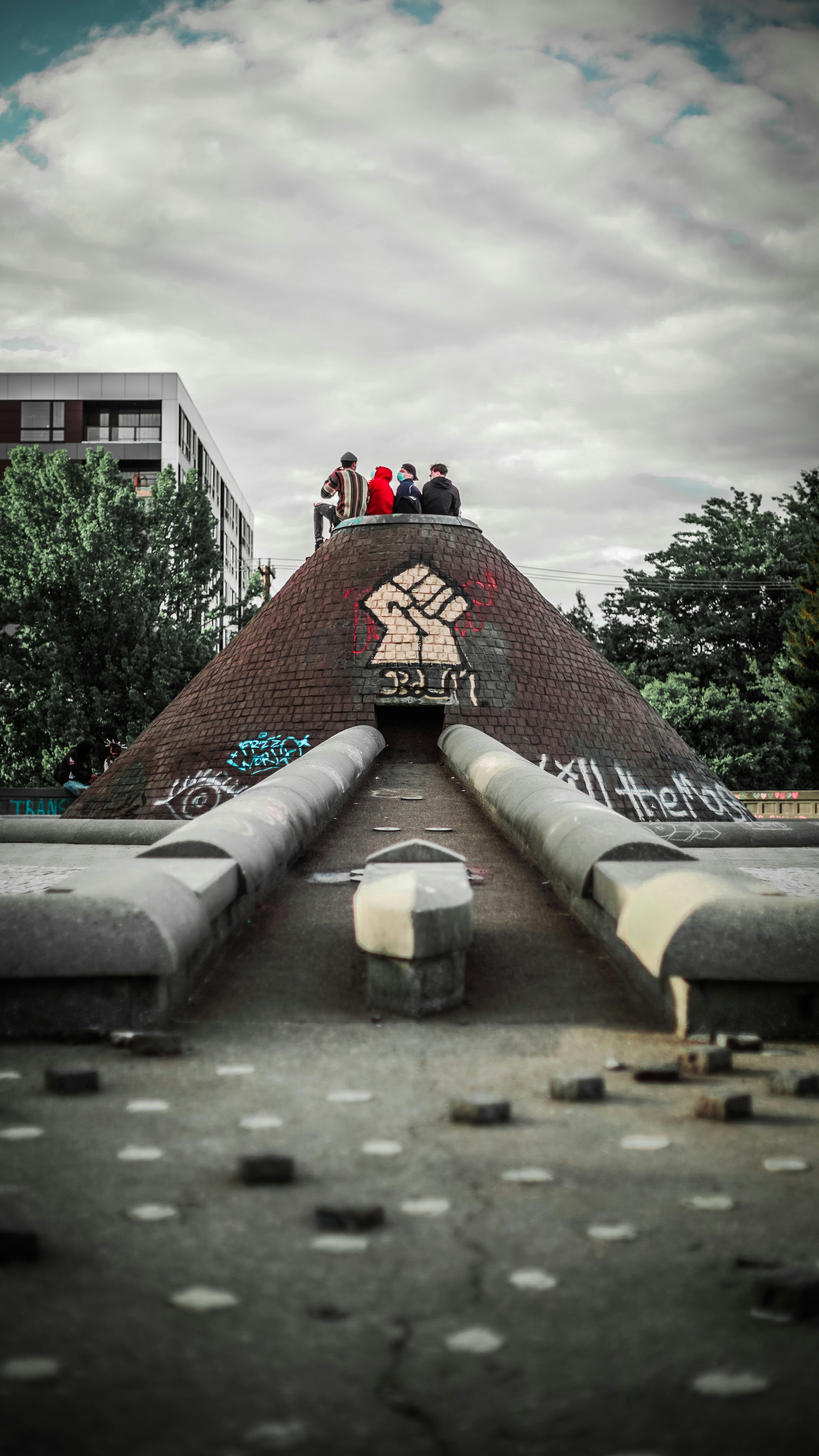 Graffiti Pyramid Summit: Rooftop Figures on a Concrete Peak
