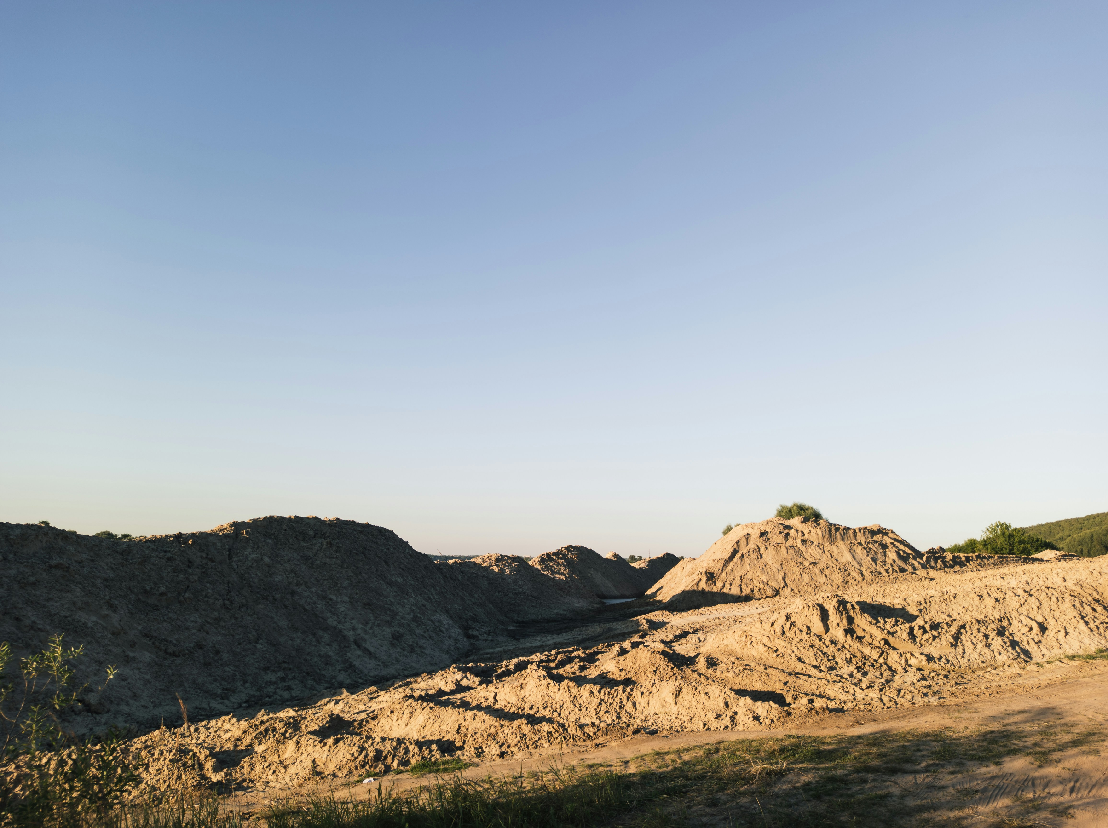 Sunlit desert hills under a clear blue sky.