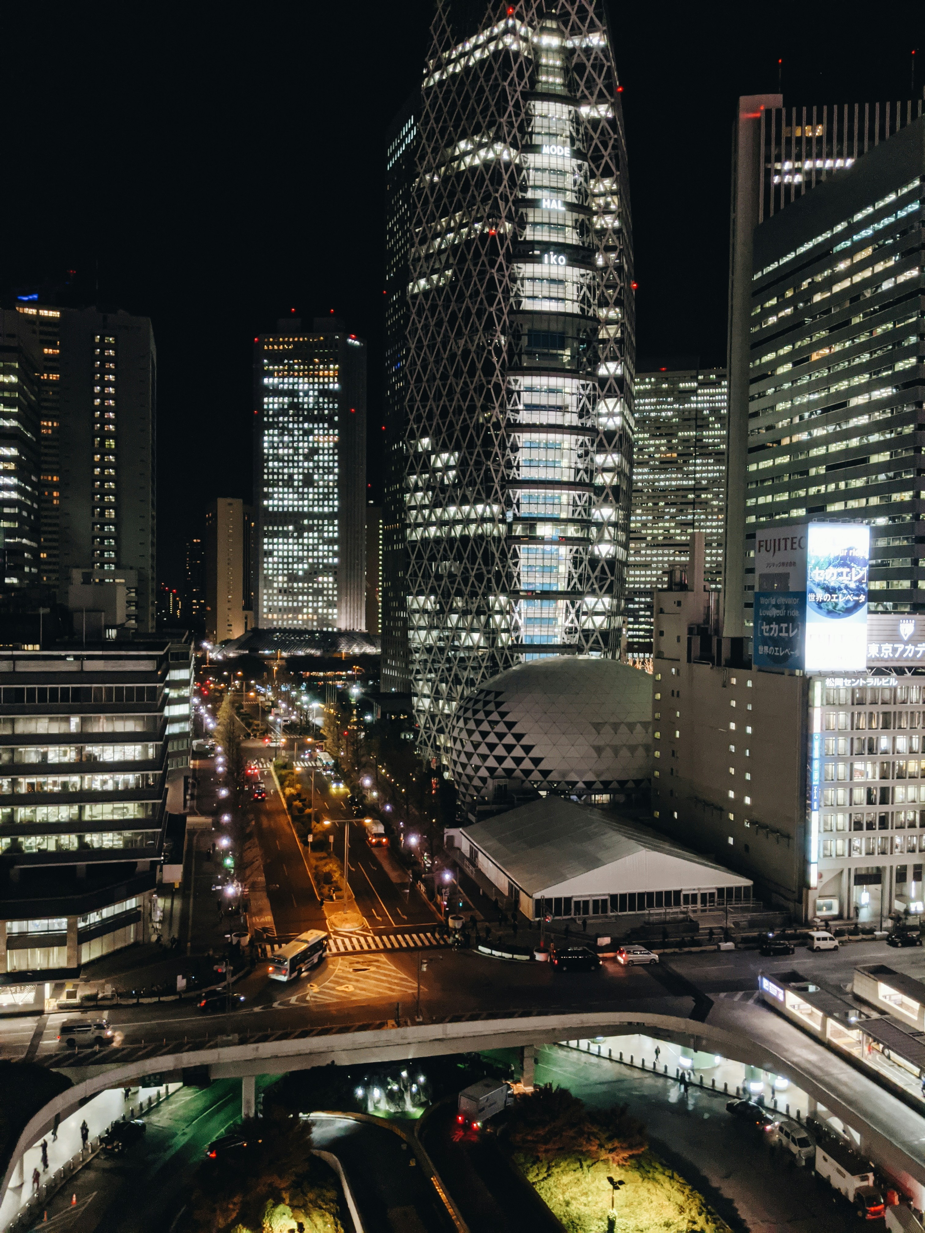 Vibrant city skyline at night featuring illuminated skyscrapers and bustling streets. The architectural diversity showcases modern urban life.