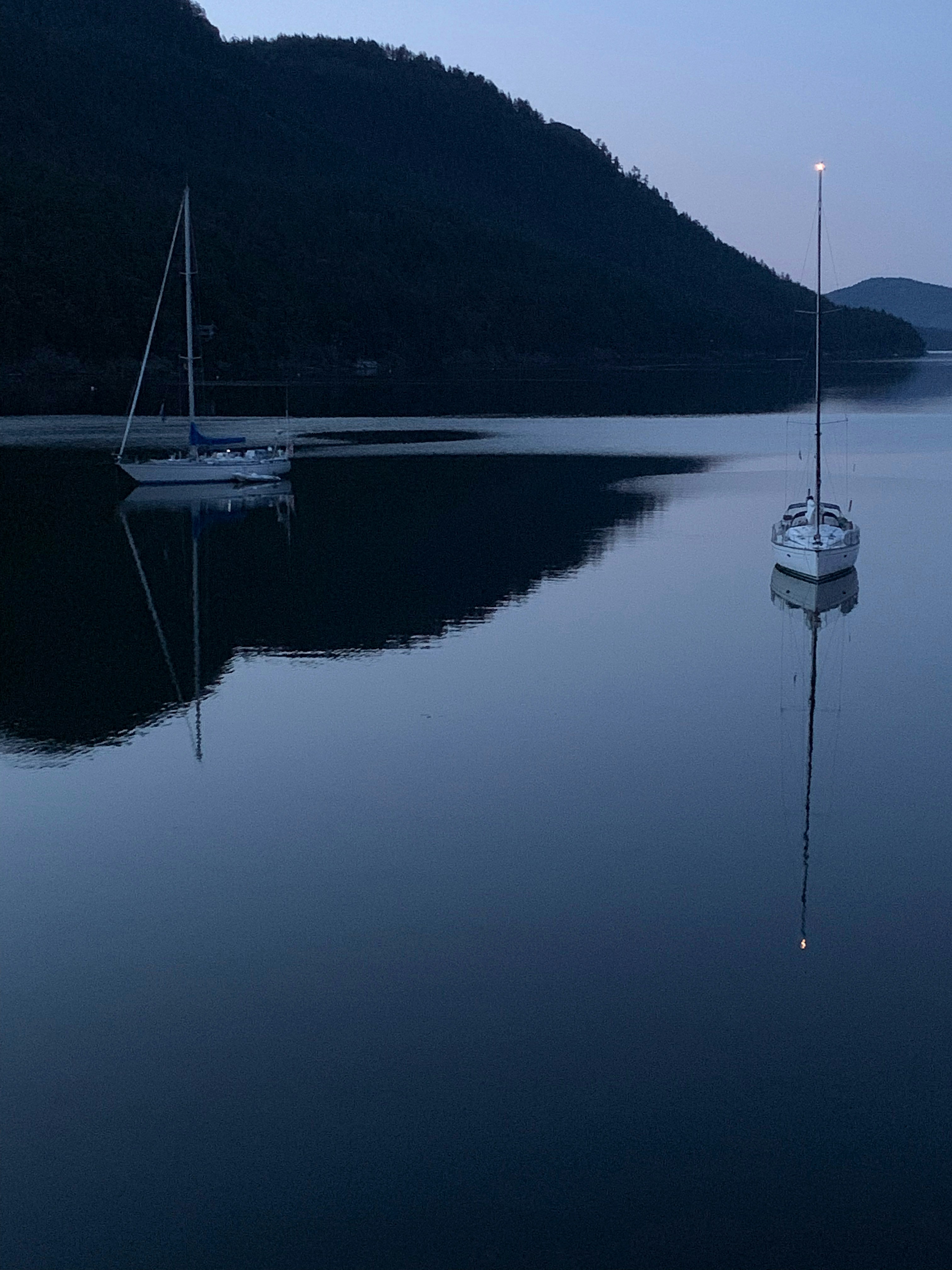 Quiet Sails at Dusk: Boats and Backlit Hills Mirror a Velvet Sea