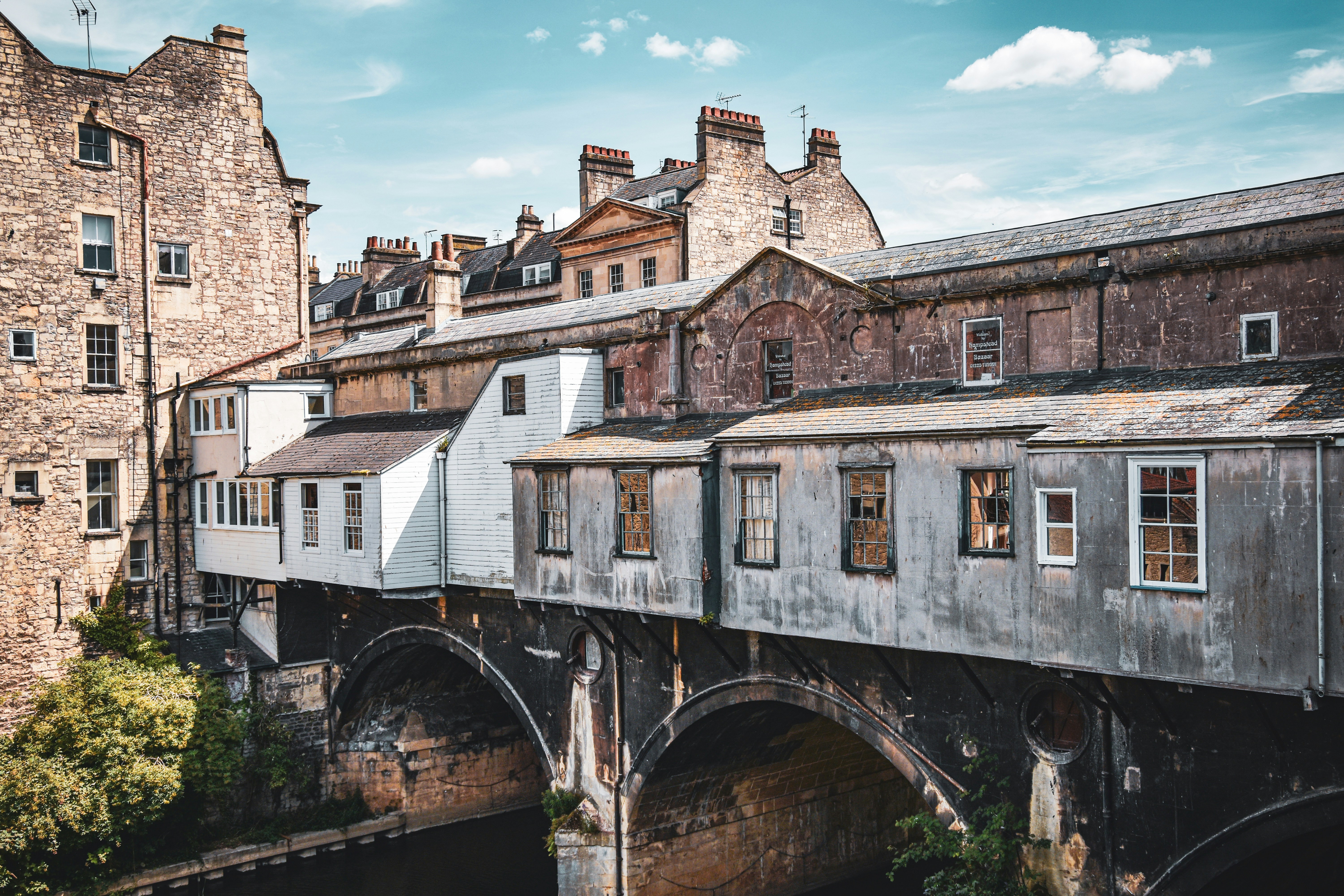 Brown and white concrete building near bridge under blue sky during ...
