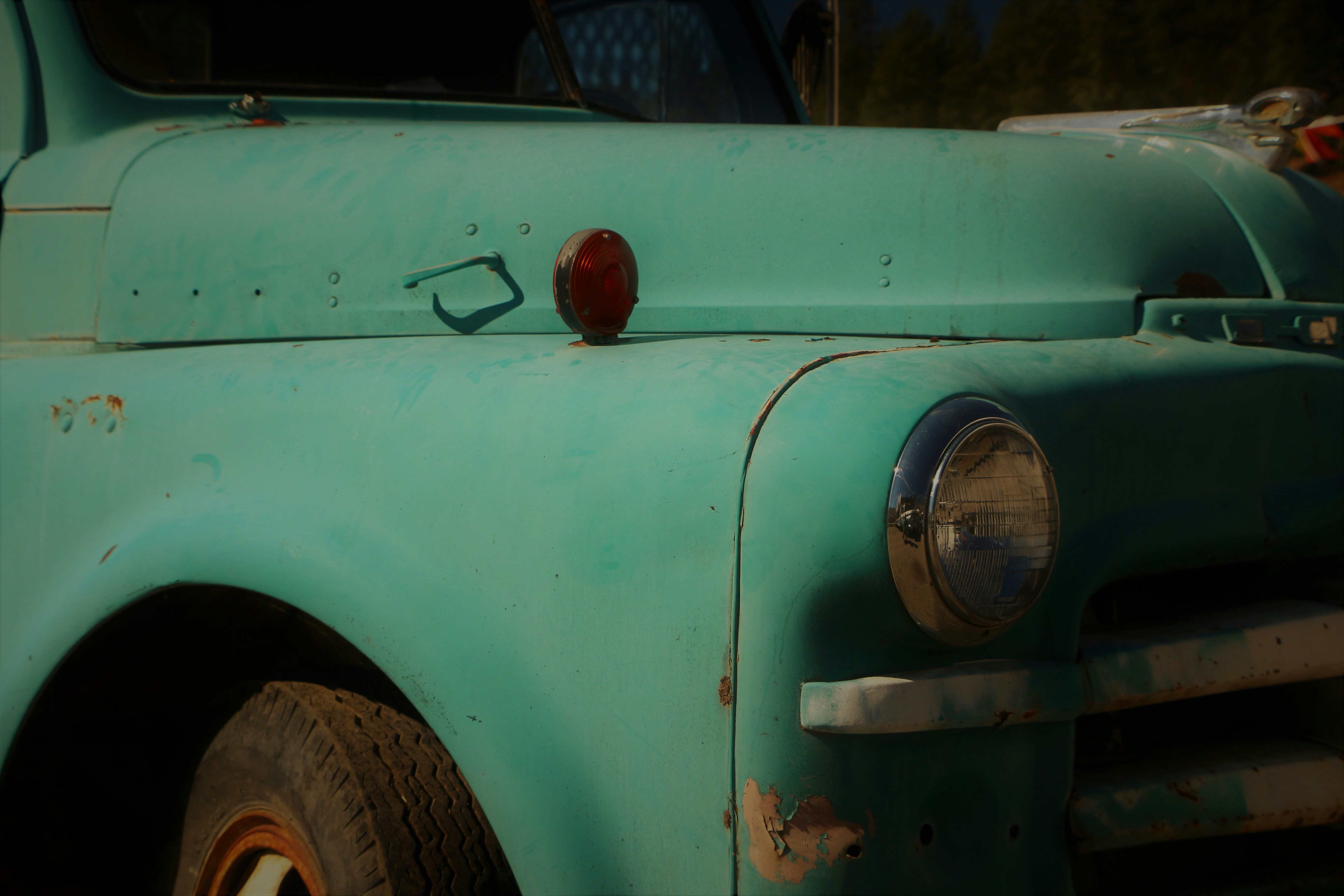 Rust-Blue Relic: The Weathered Front of a Vintage Turquoise Truck